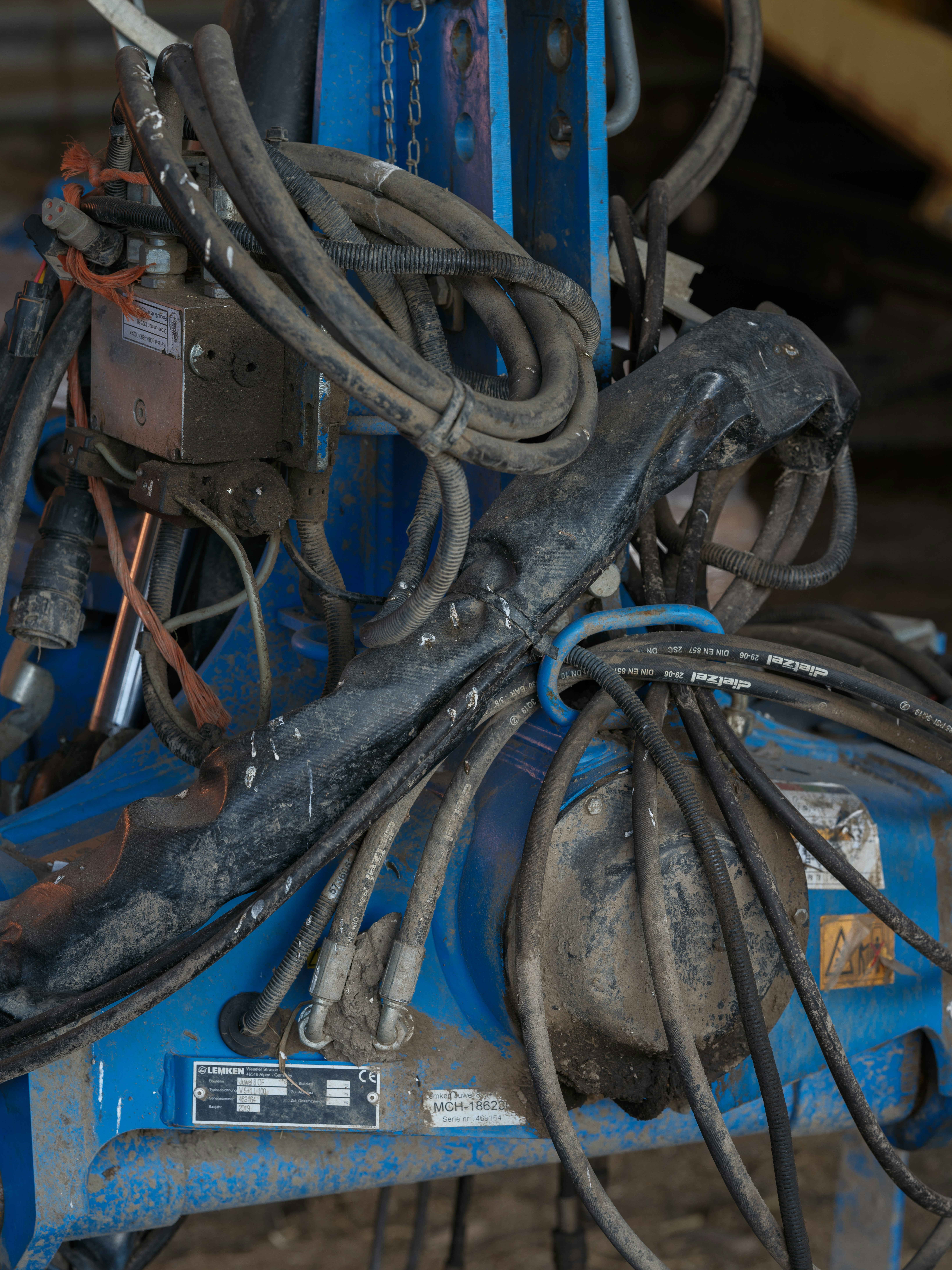 Blue Hydraulic Core: A Close-Up of Wires, Levers, and Dust in a Workshop