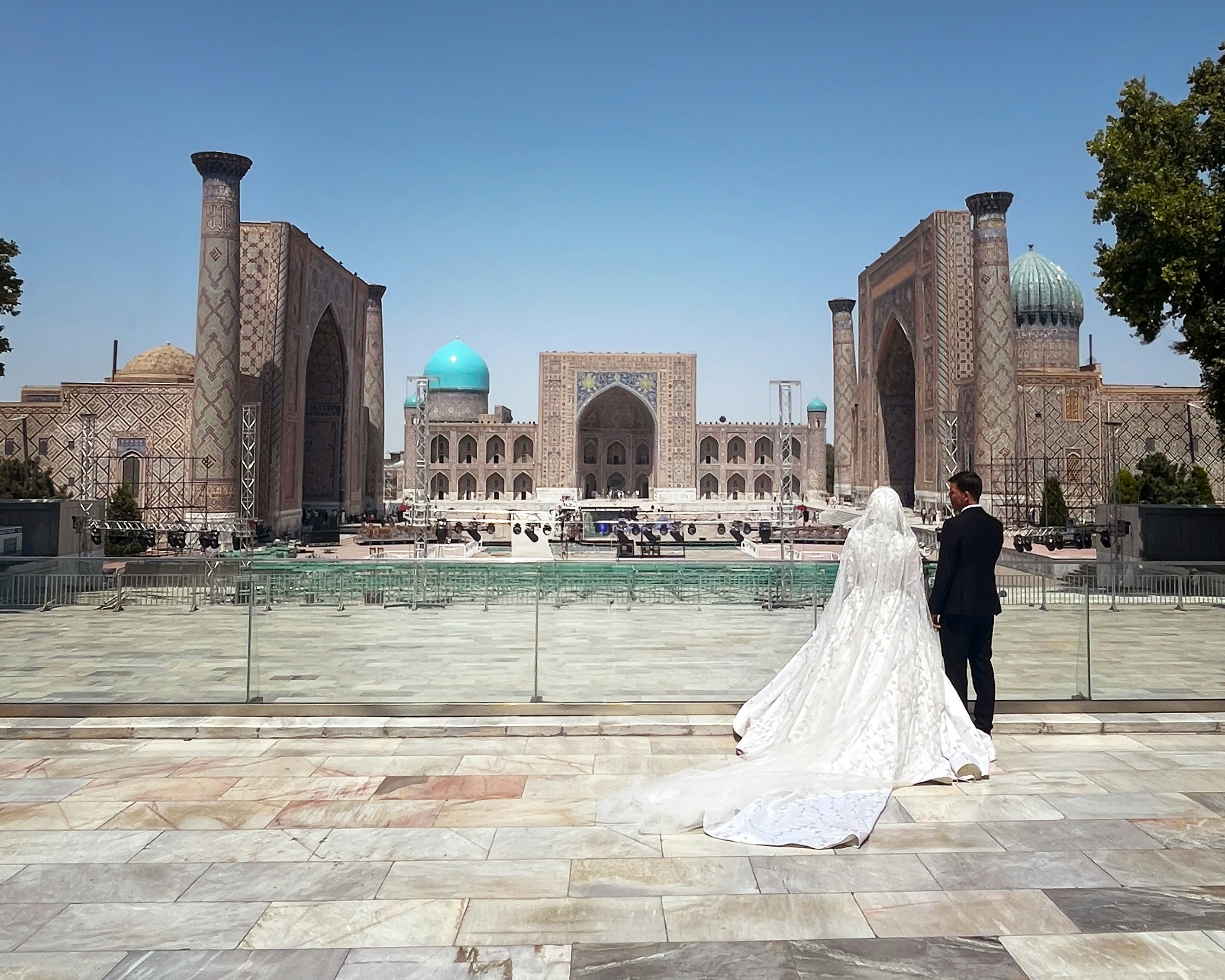 A bride and groom standing in front of a large building photo – Free ...