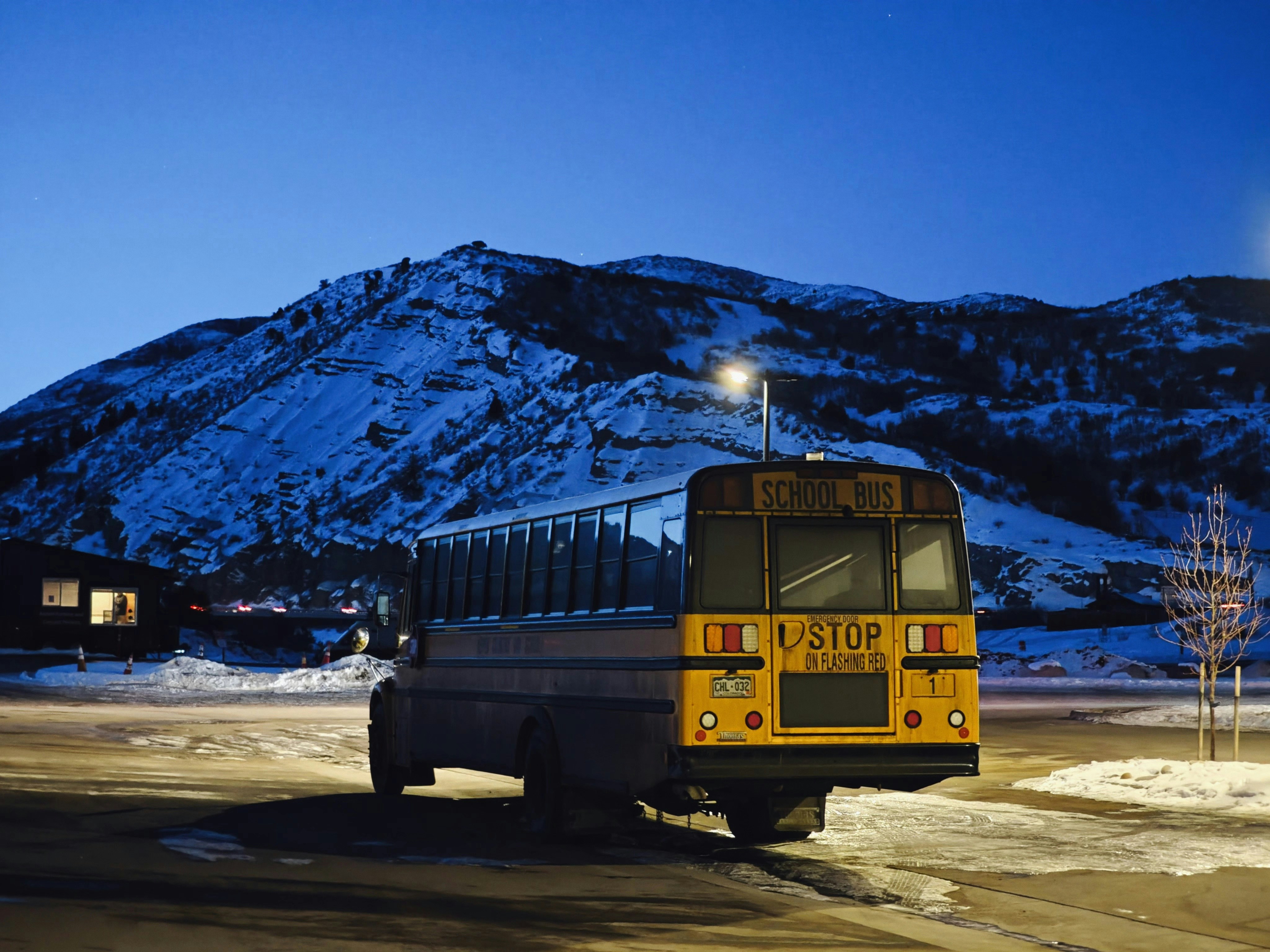 A yellow school bus parked in front of a mountain photo – Free Aspen ...