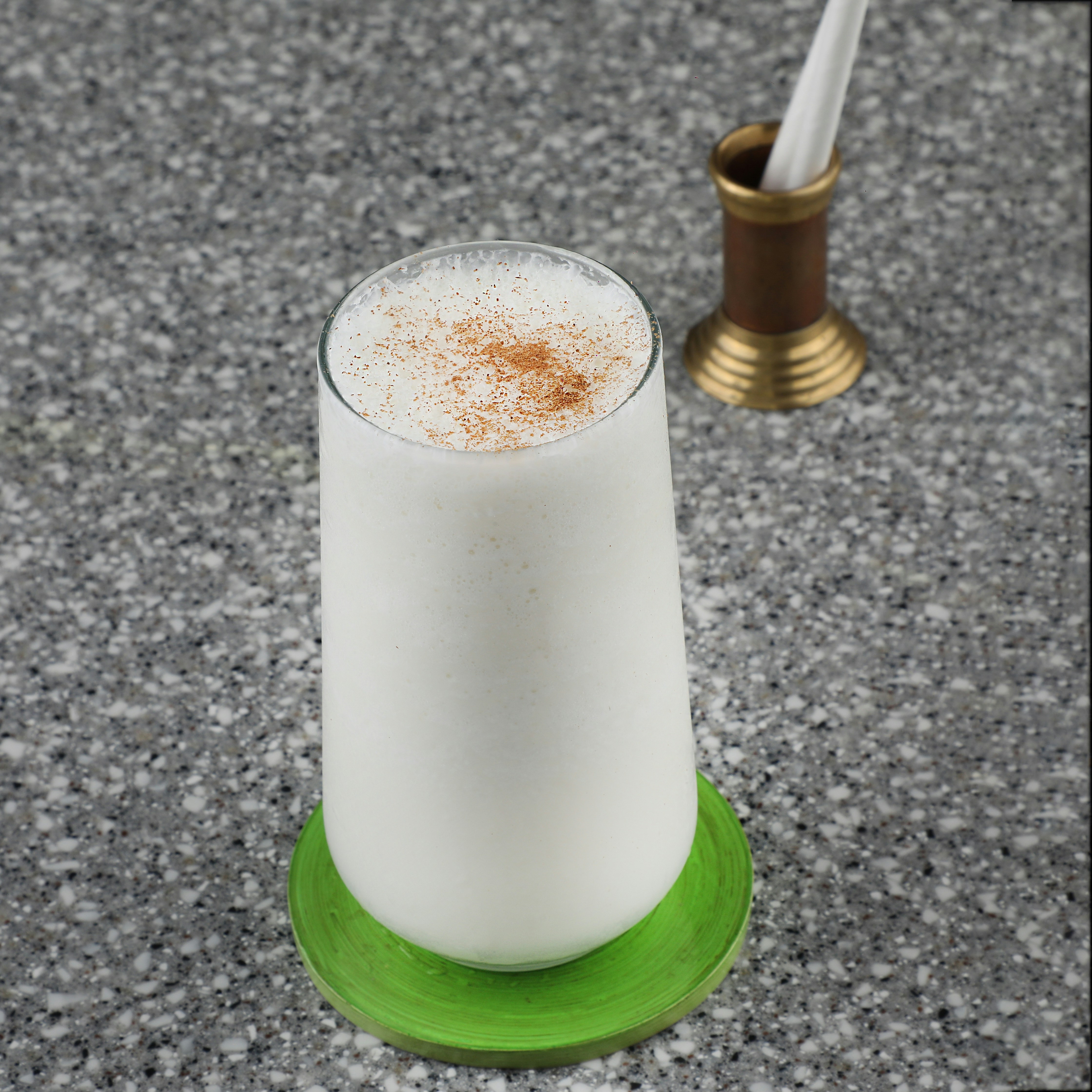 Milk Foam on a Lime Coaster: Quiet Portrait on a Speckled Counter