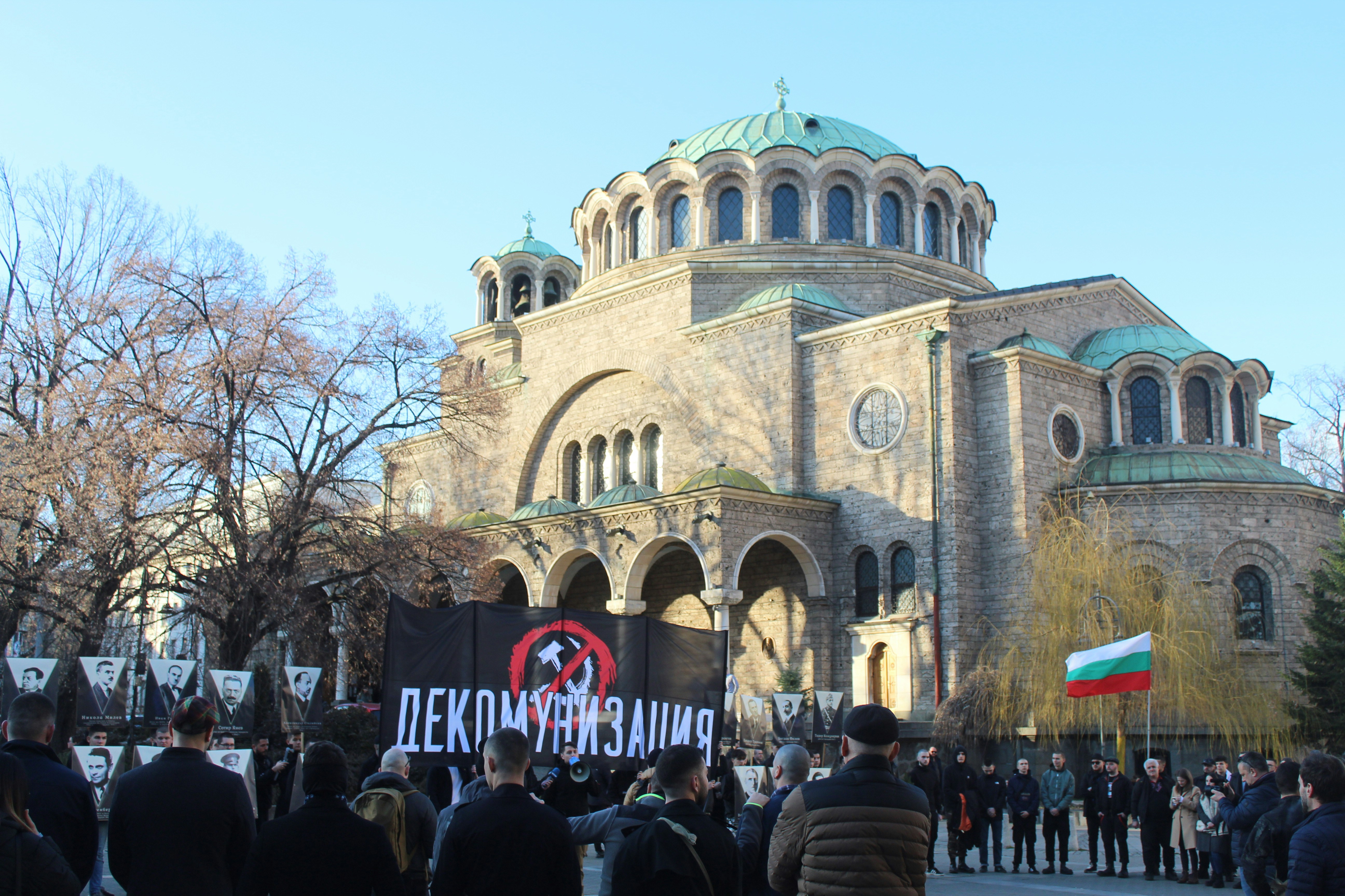 Crowd assembled in front of a historic domed building under a clear blue sky.