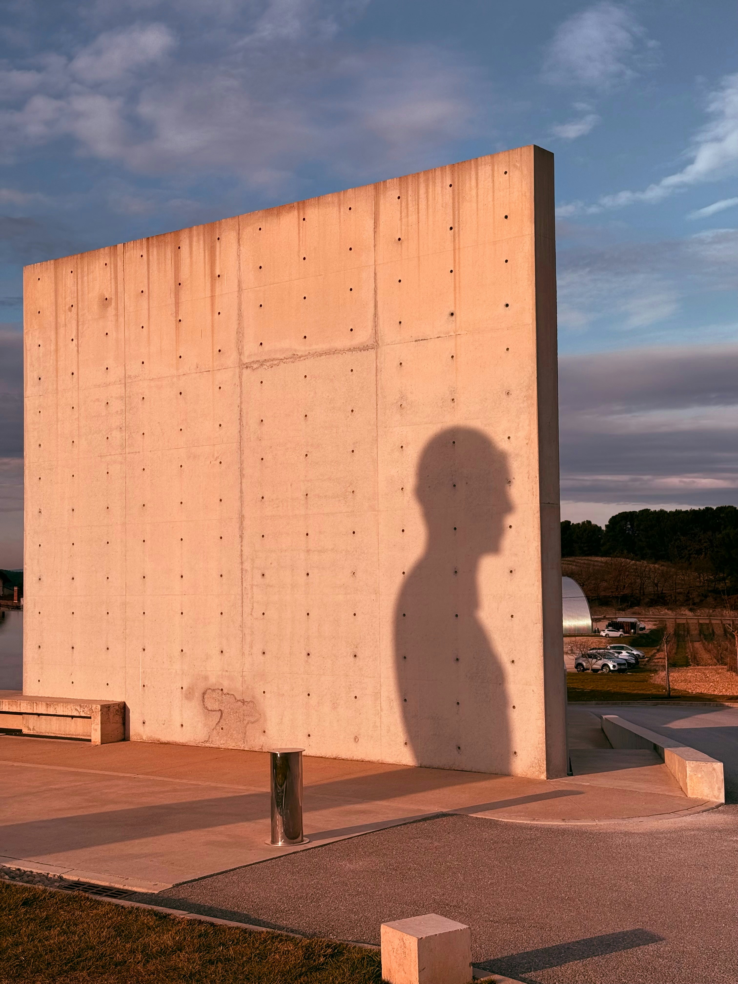 Silhouette at Sundown: A Quiet Shadow on a Monumental Concrete Wall