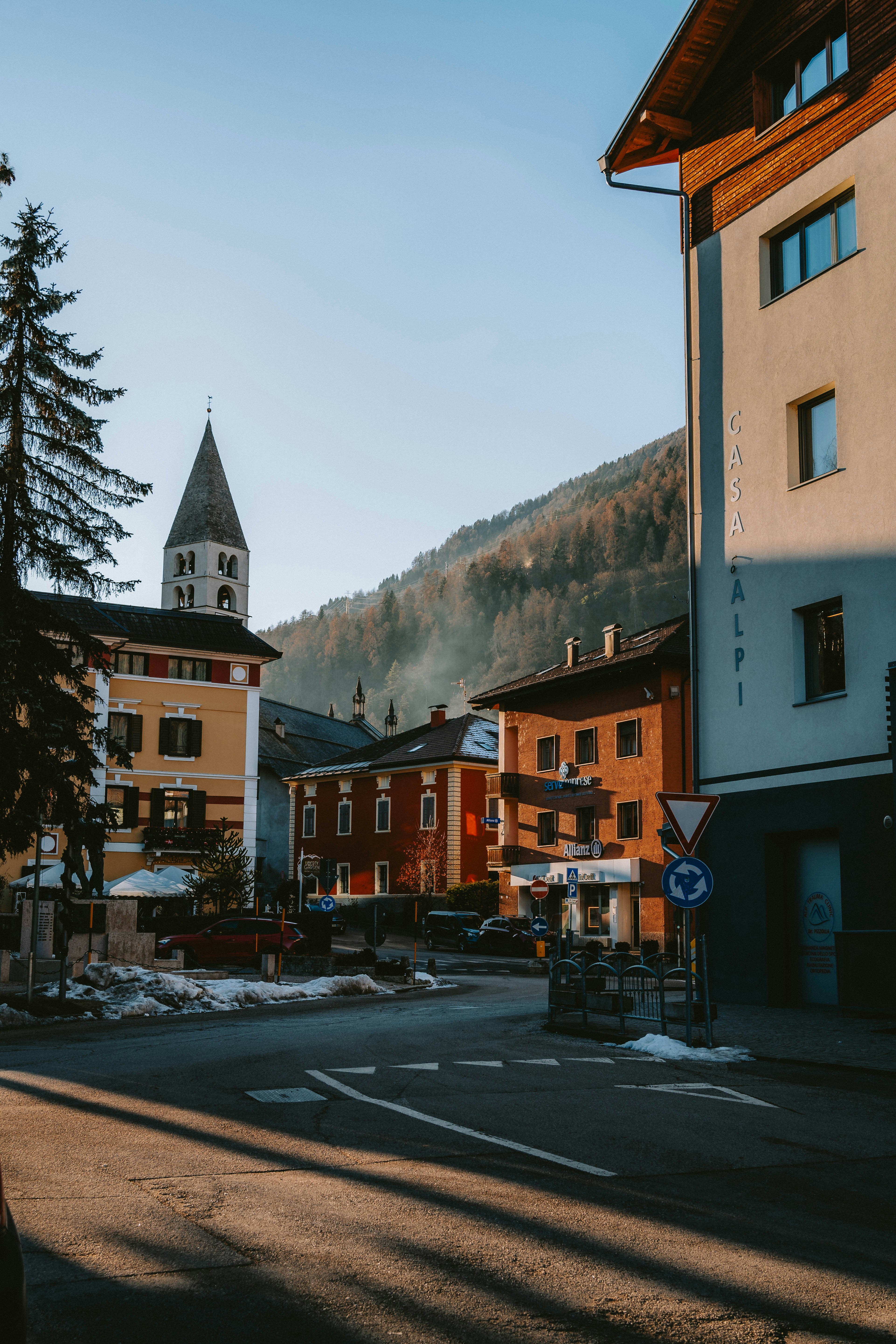 Clocktower Dawn in the Alps: Sunlit Street of Pastel Facades