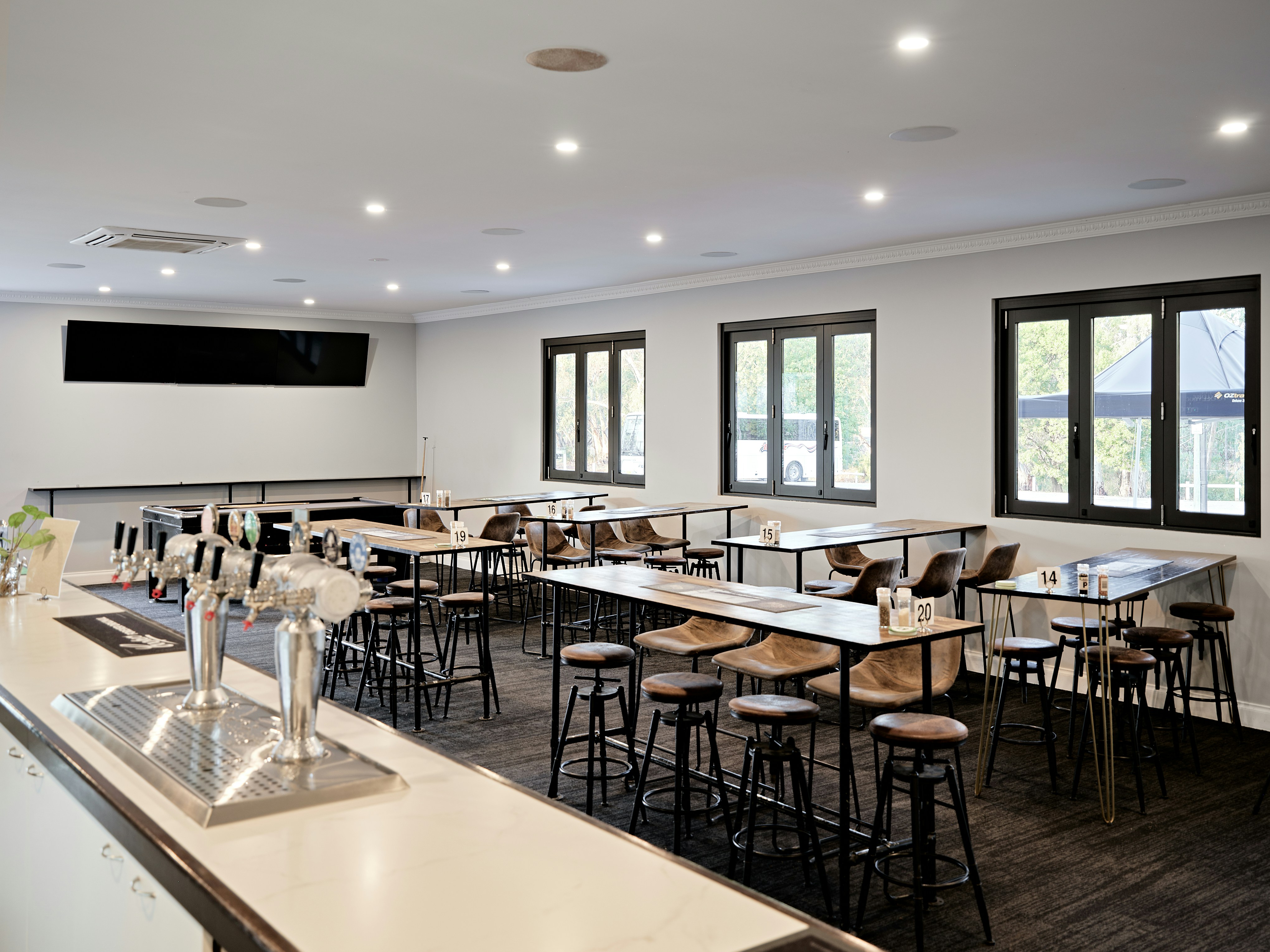 A large room with tables and chairs and a projector screen photo – Free ...