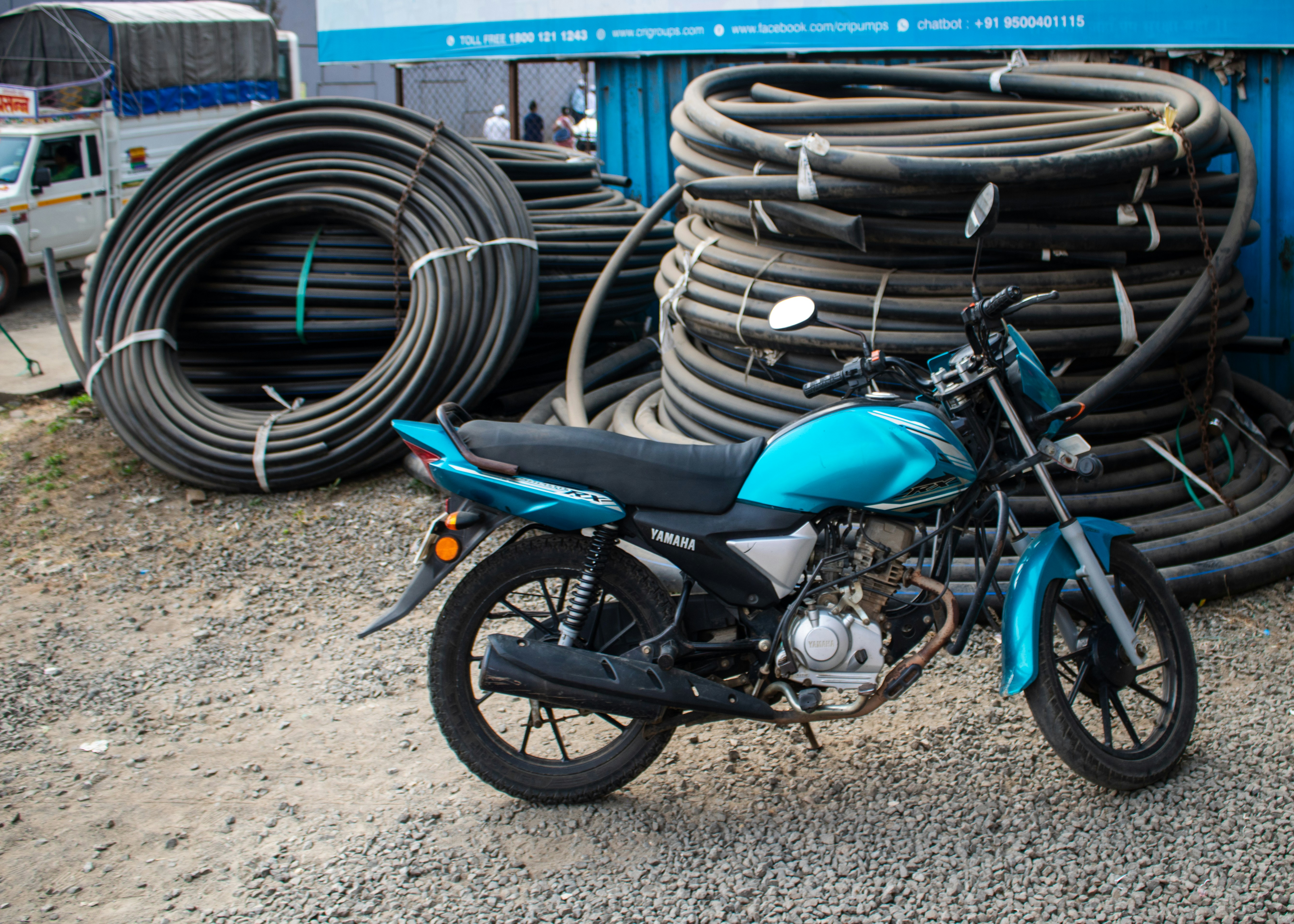 Blue Yamaha on a Gravel Lot Among Coiled Cables