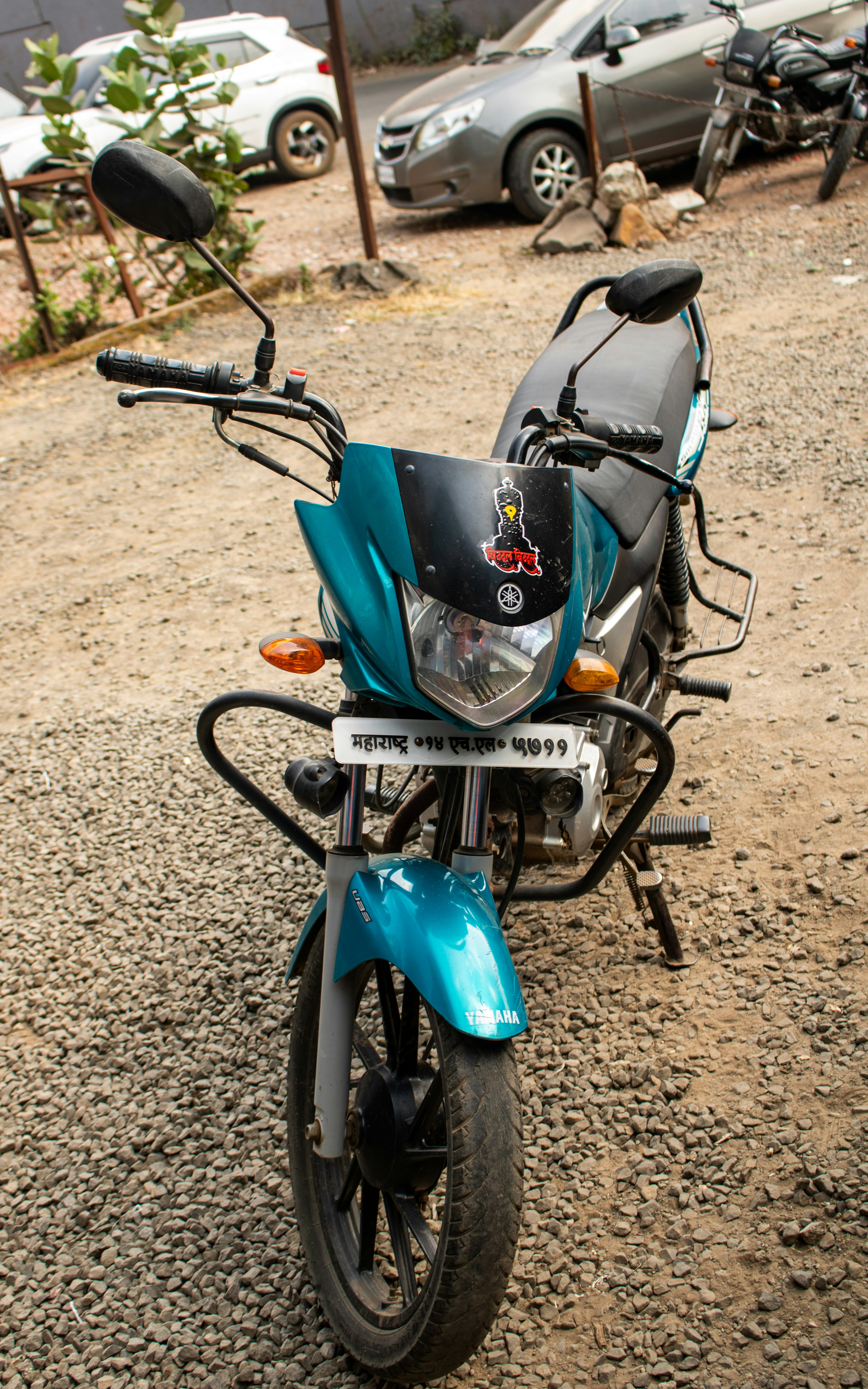 Blue Yamaha in a Gravel Lot: Front-Facing Portrait of a Street Bike