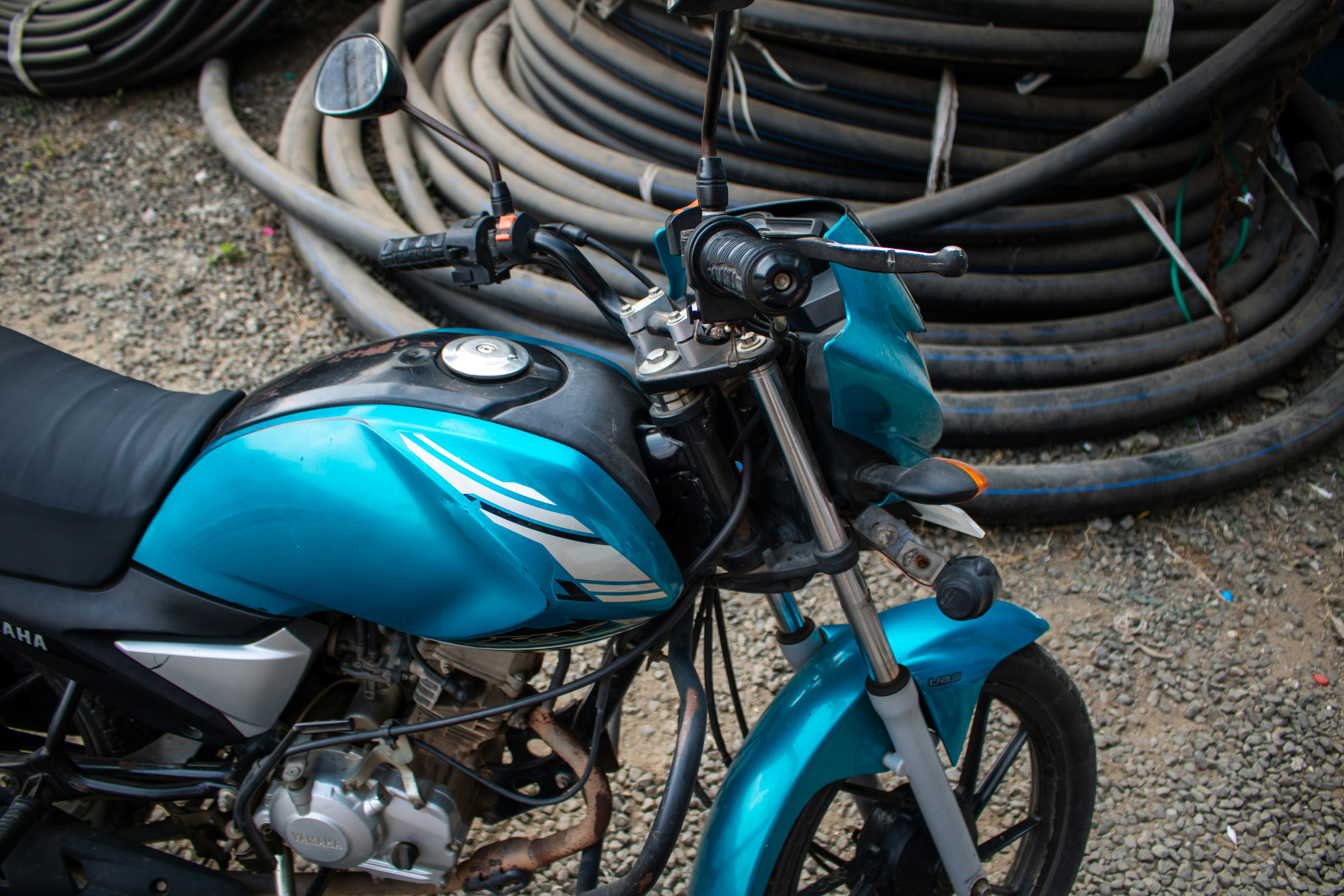 A blue motorcycle parked next to a bunch of hoses photo – Free Blue ...