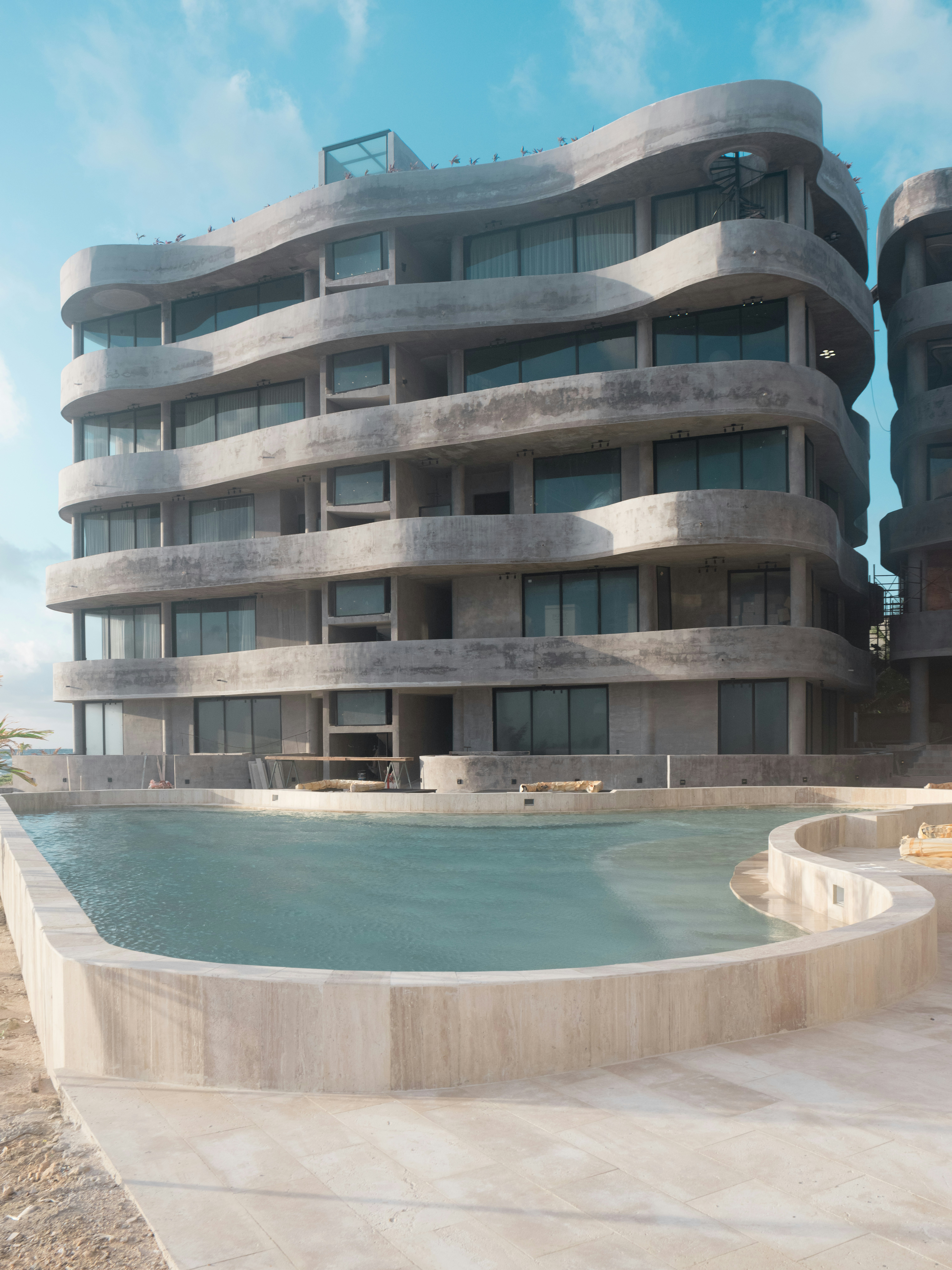 Curved Concrete Oasis: A Modernist Building by the Pool