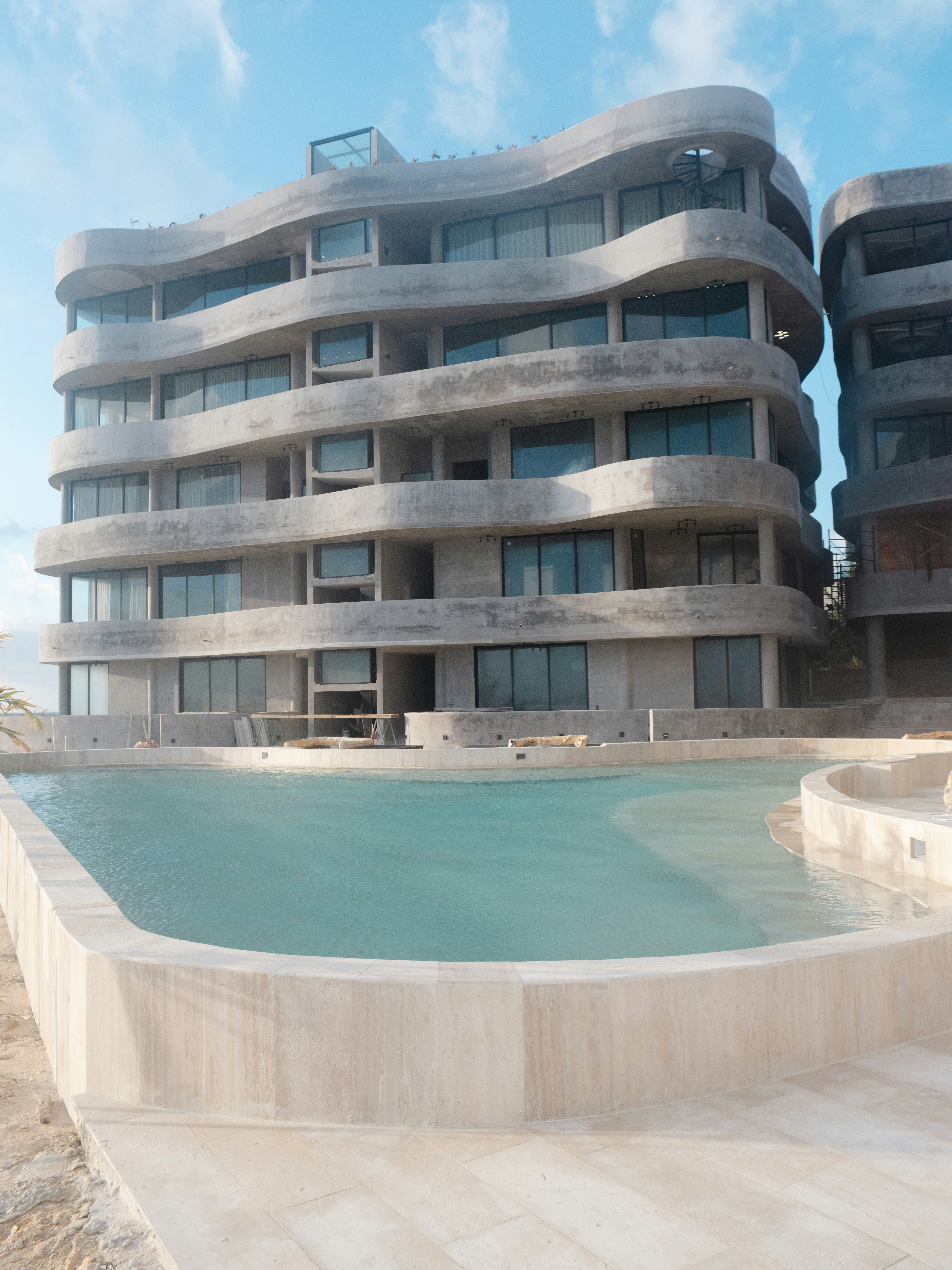 A large building with a pool in front of it photo – Free City Image on ...