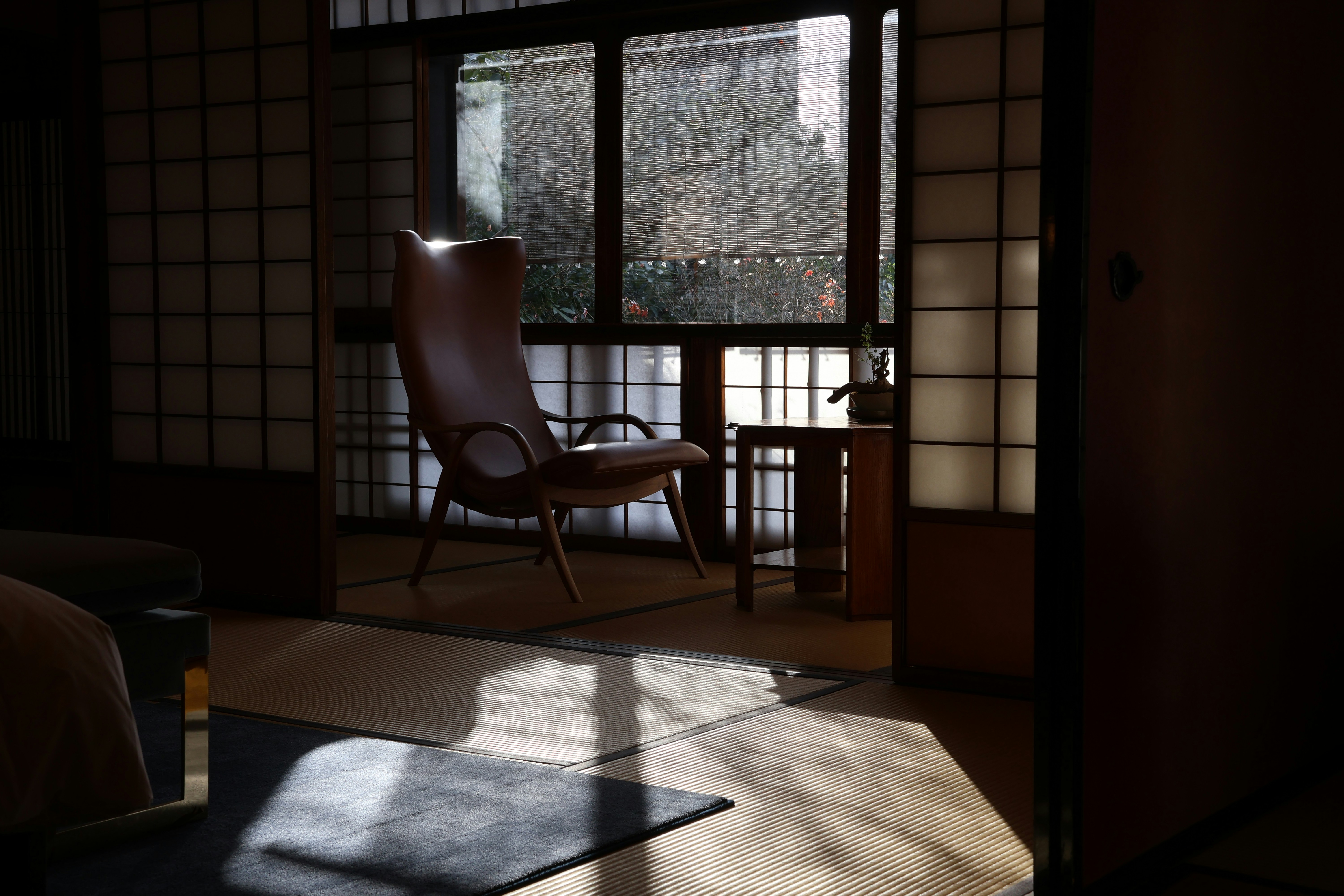 Sunlit chair in a serene room with shoji screens and a view of the outdoors.