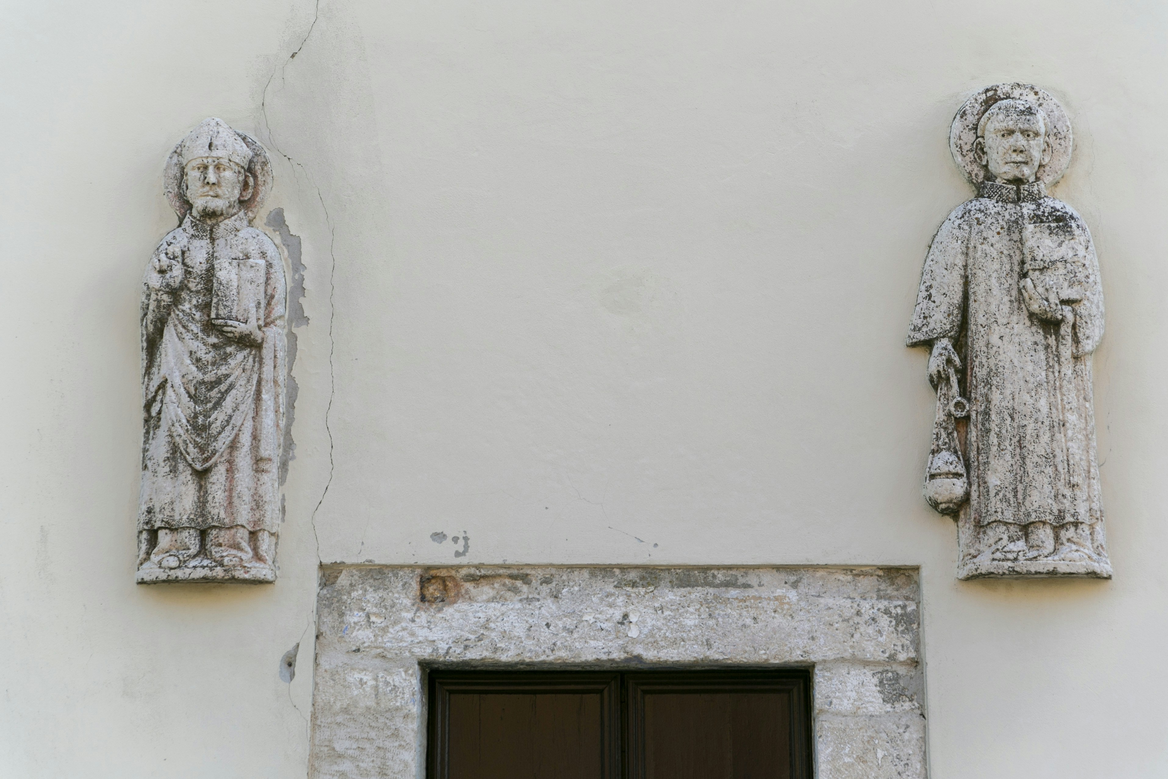 Guardians in Stone: A Pale Facade Framed by Silent Statues