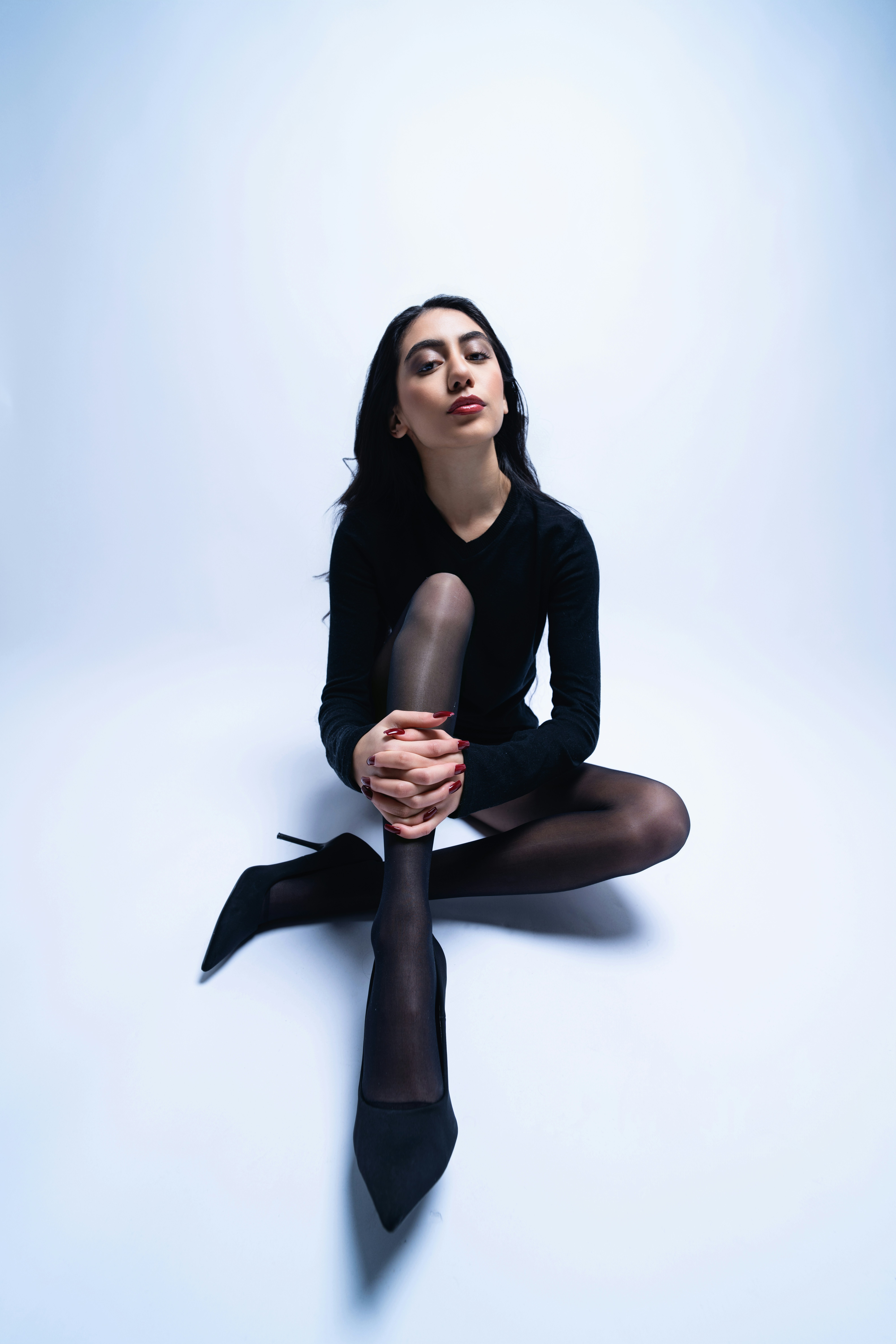 Noir Studio Poise: A Quiet Portrait in a White Studio Backdrop