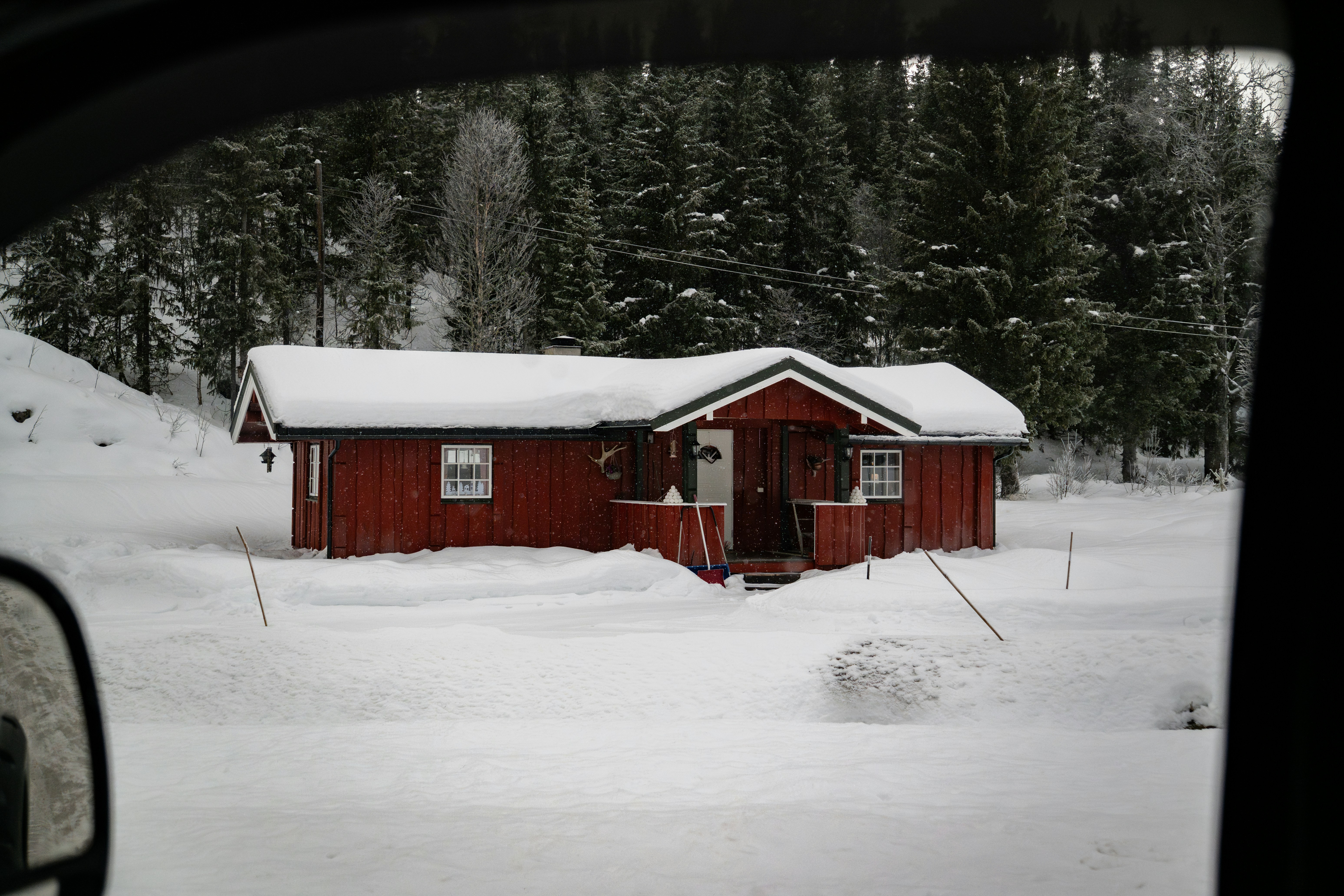 Red Cabin in a Snowbound Clearing Framed by Pines