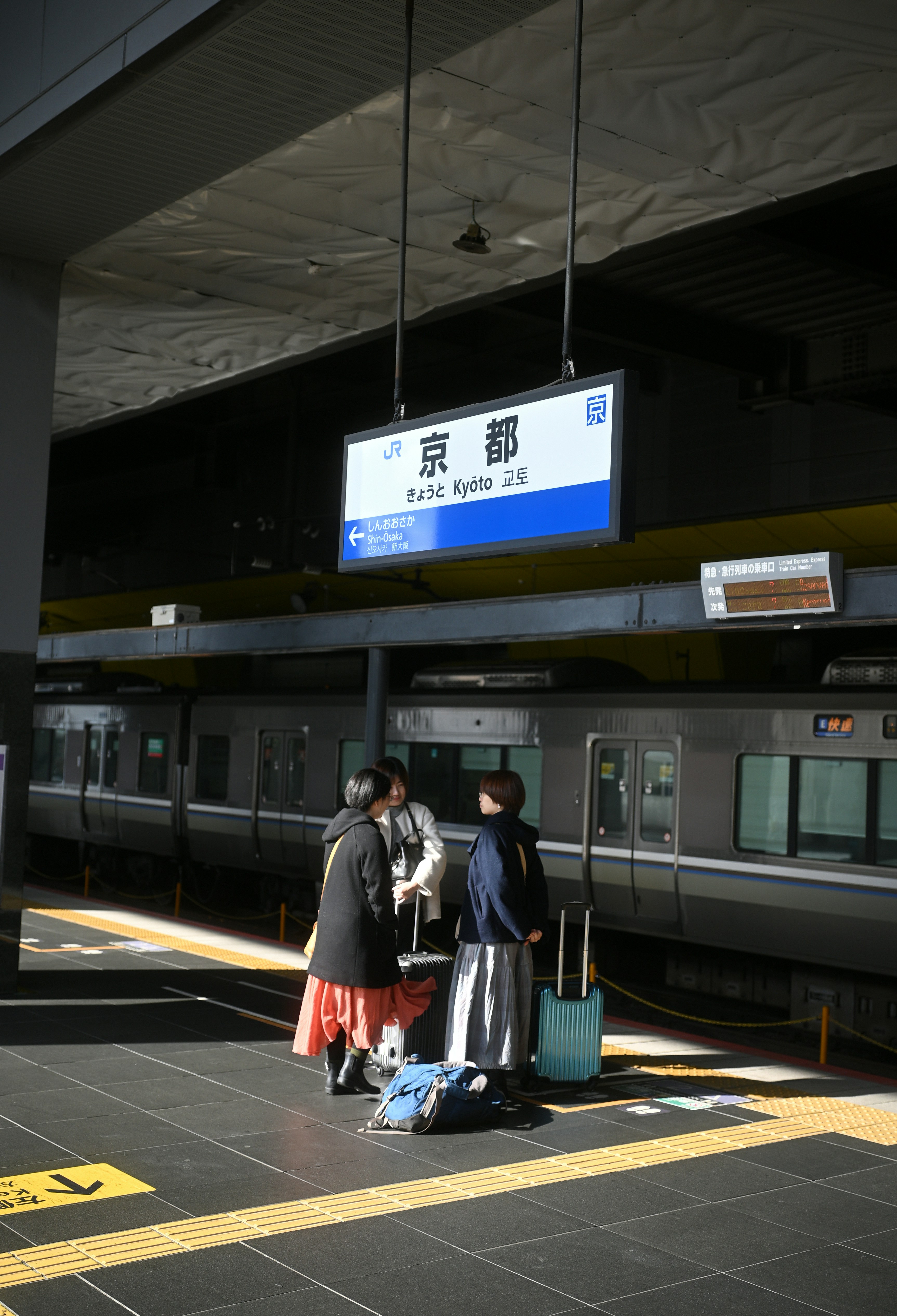 A group of people standing next to a train at a train station photo ...