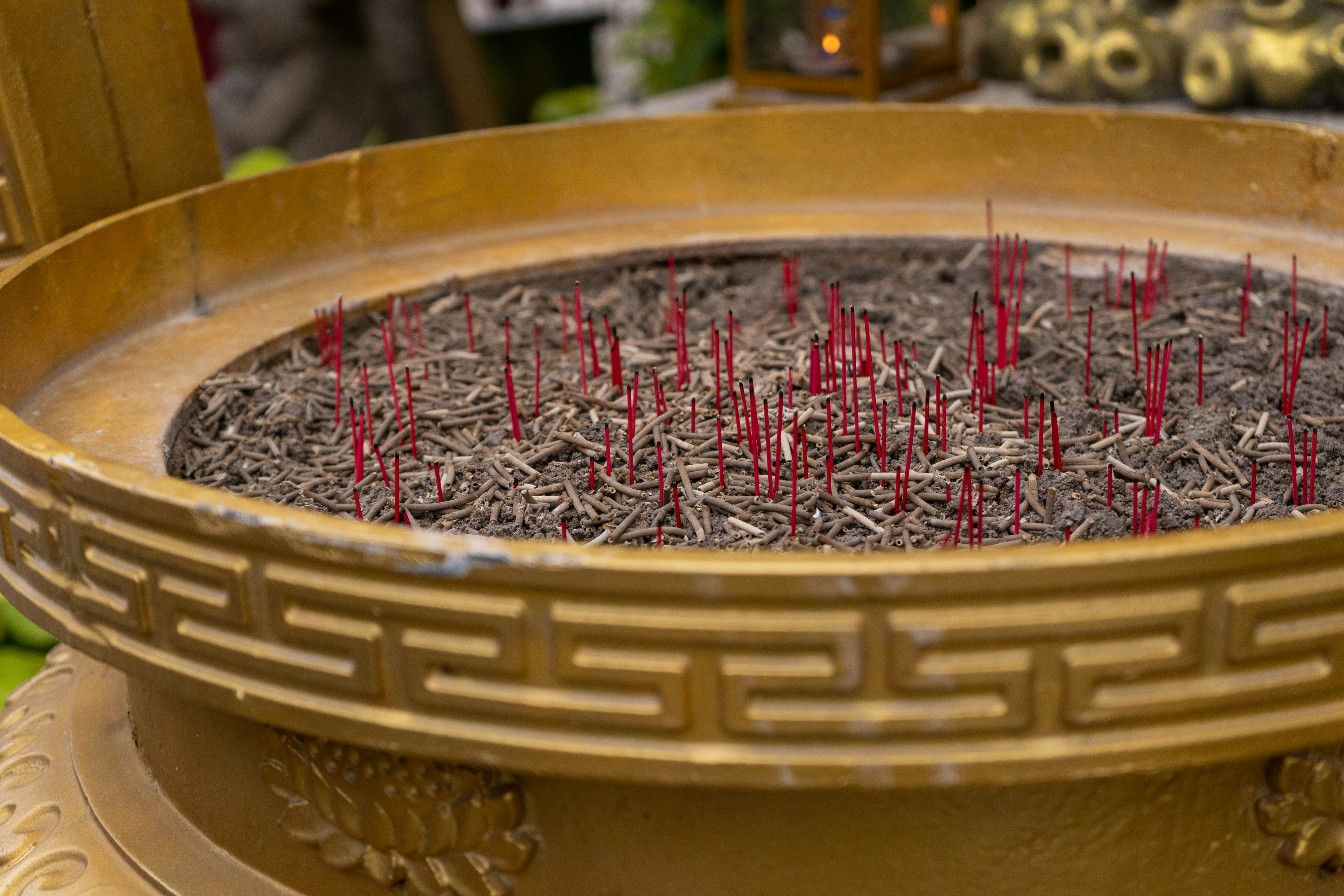 Crimson Sticks in a Gilded Vessel: A Quiet Temple Ritual