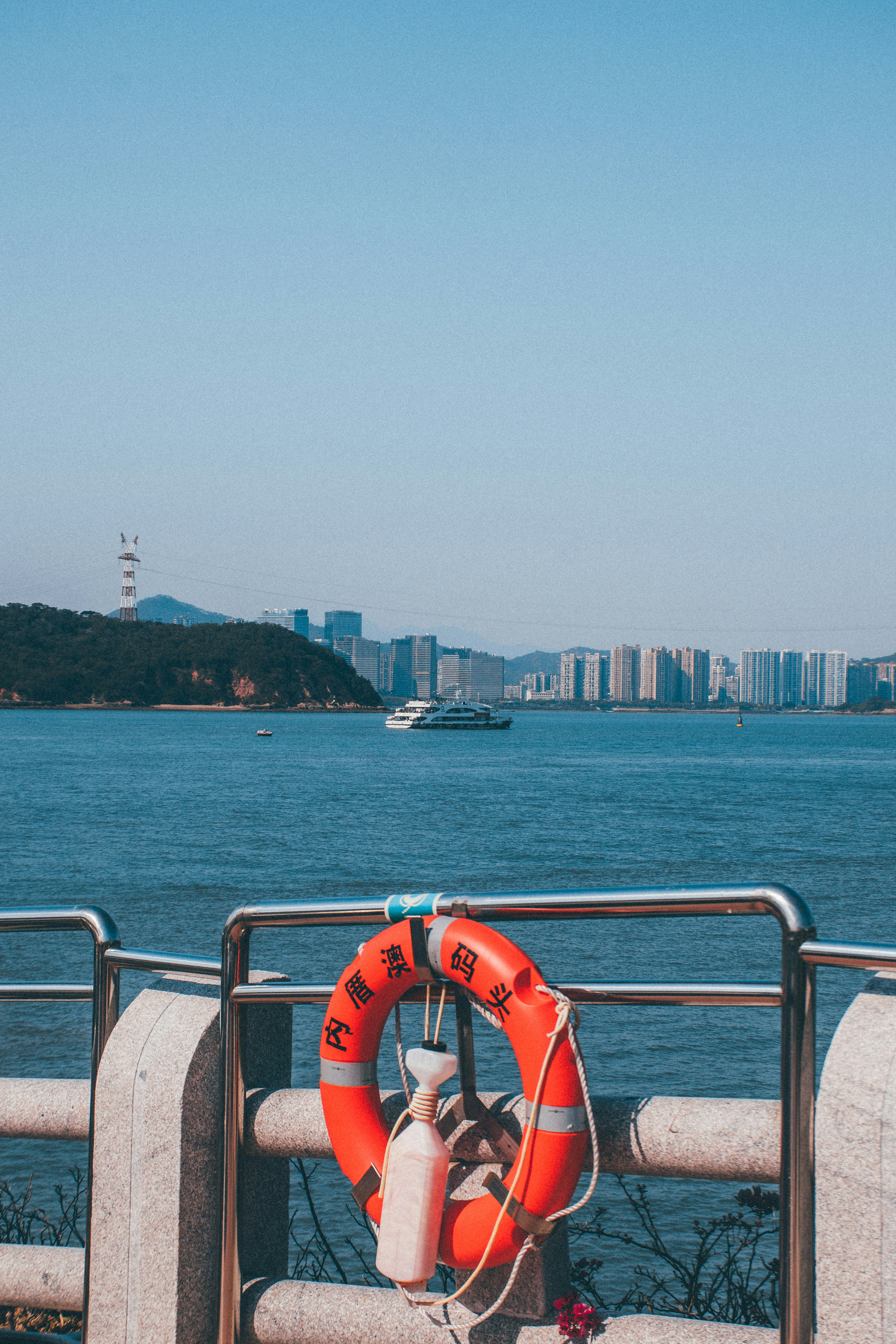 A life preserver on a railing overlooking a body of water photo – Free ...
