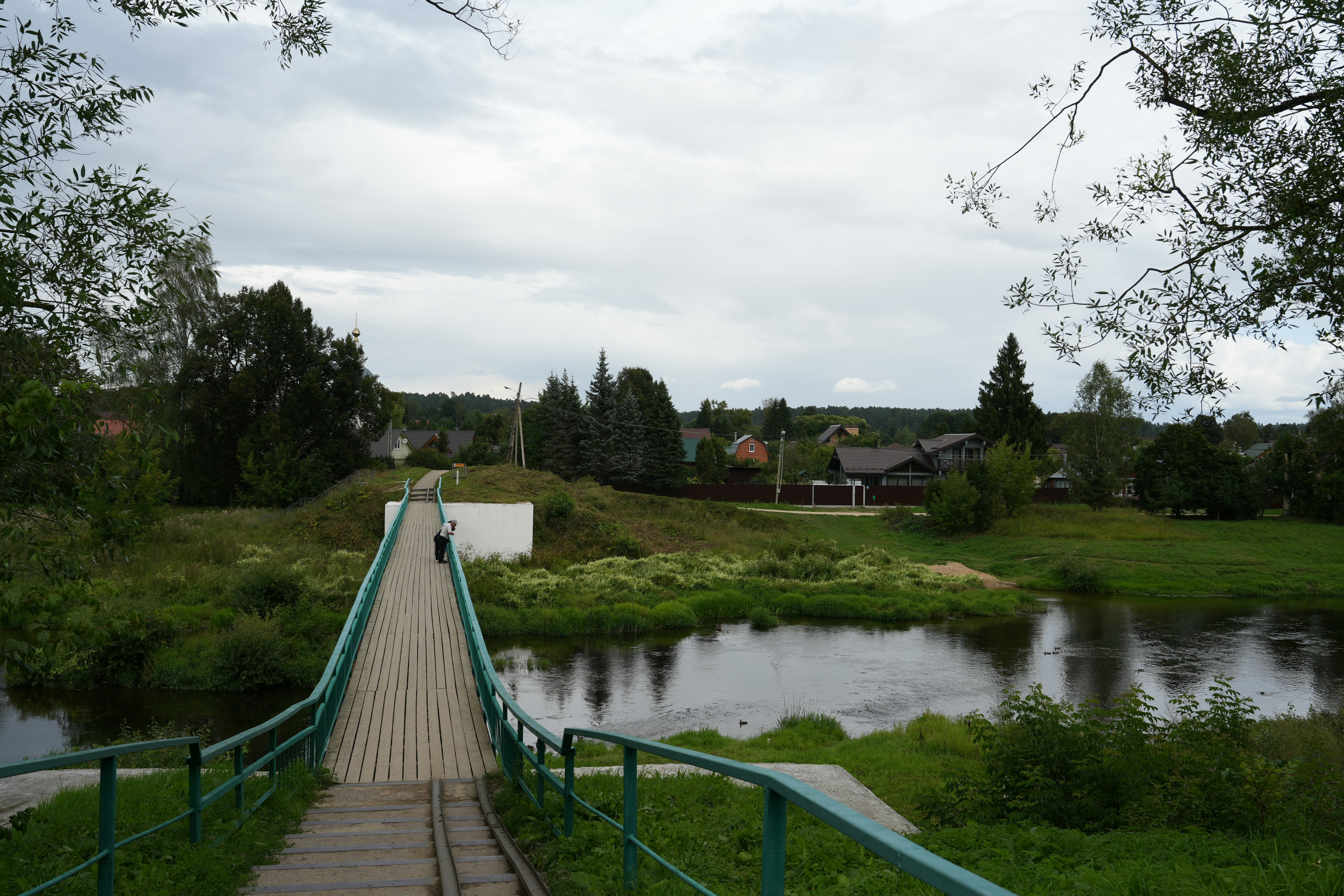 A wooden bridge crossing over a small river photo – Free Human Image on ...