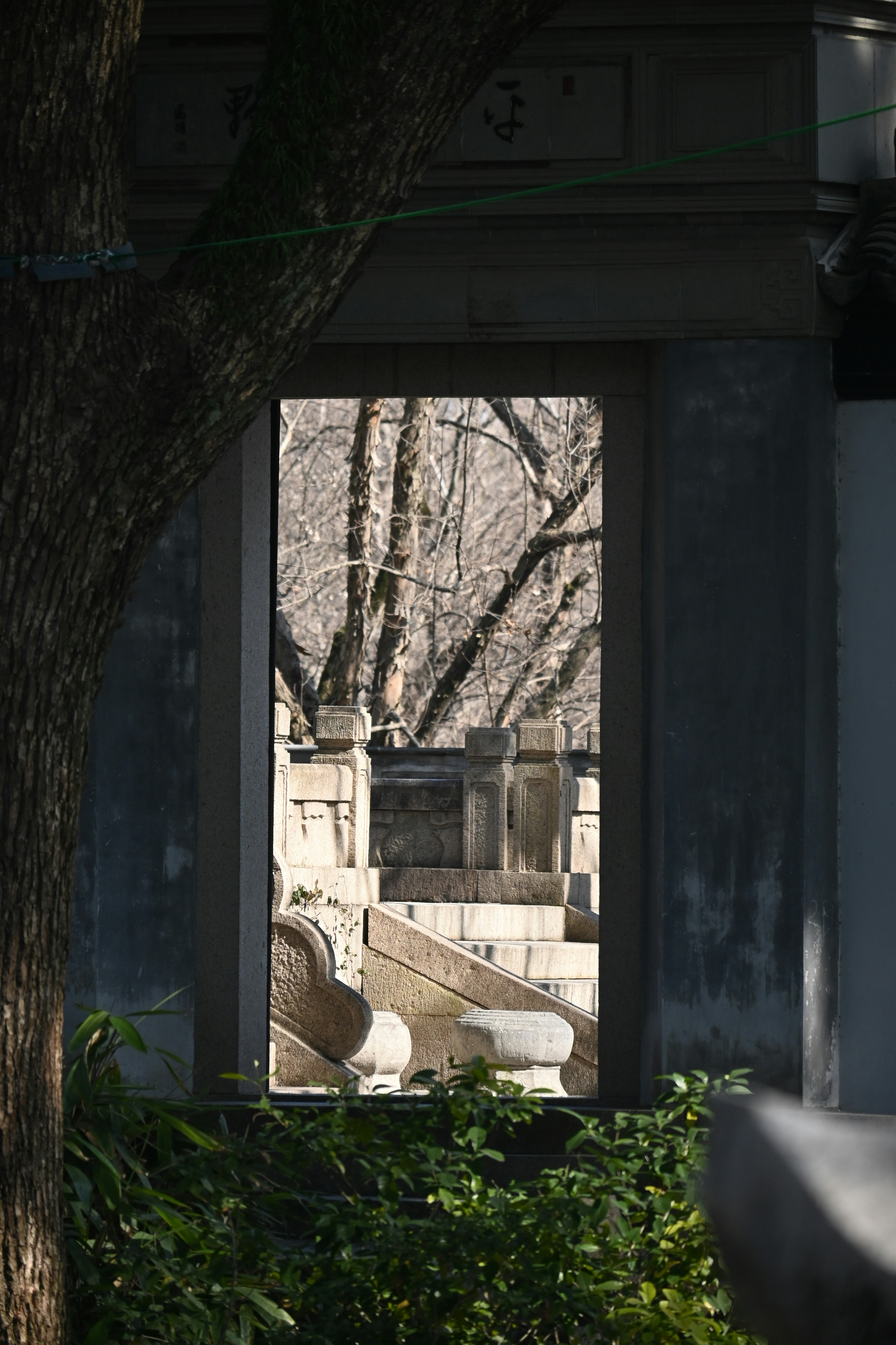 Framed Silence: Sunlit Stone Courtyard Through an Ancient Gate