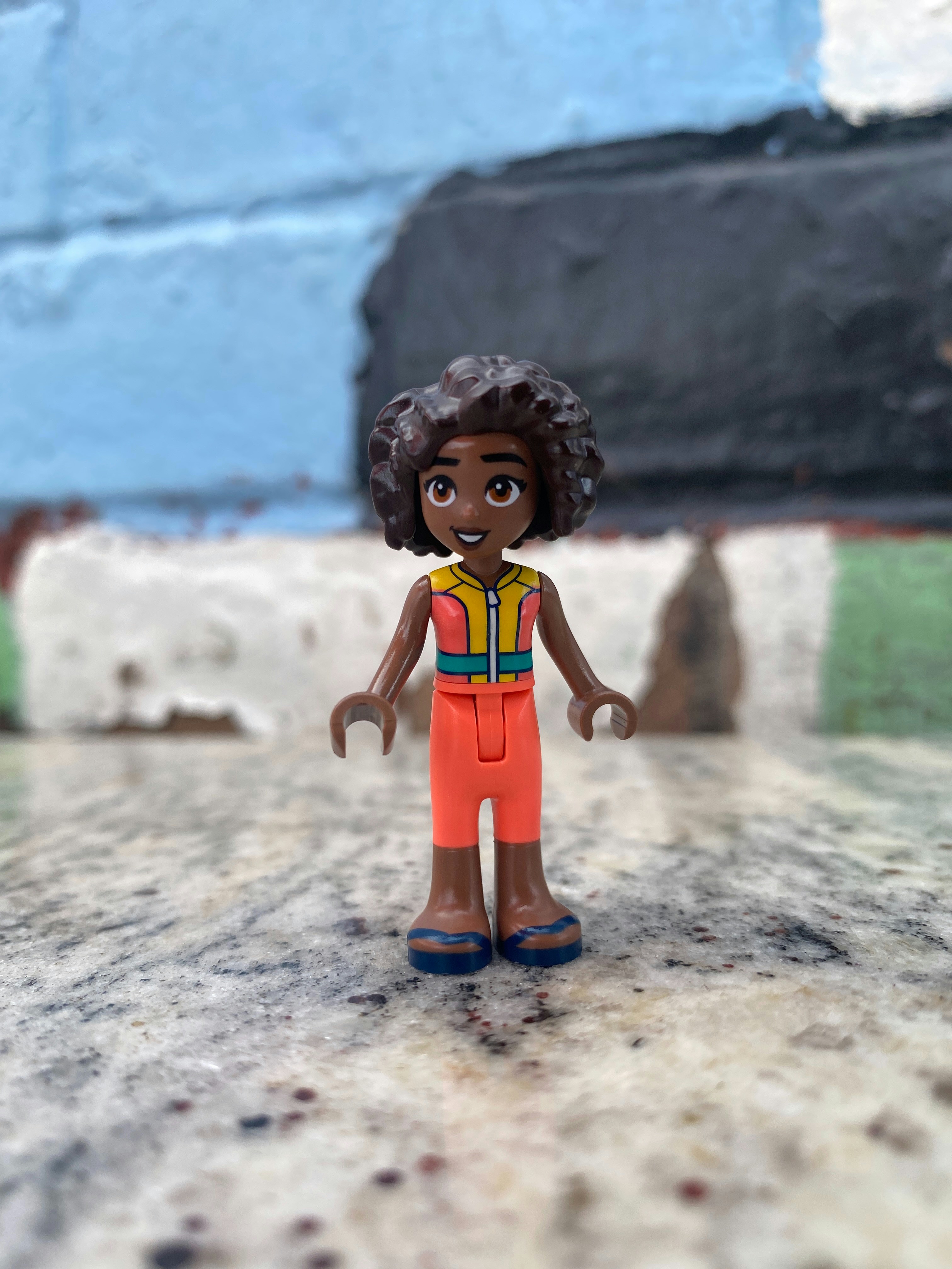 Tiny Trailblazer on a Speckled Counter Before a Painted Brick Backdrop