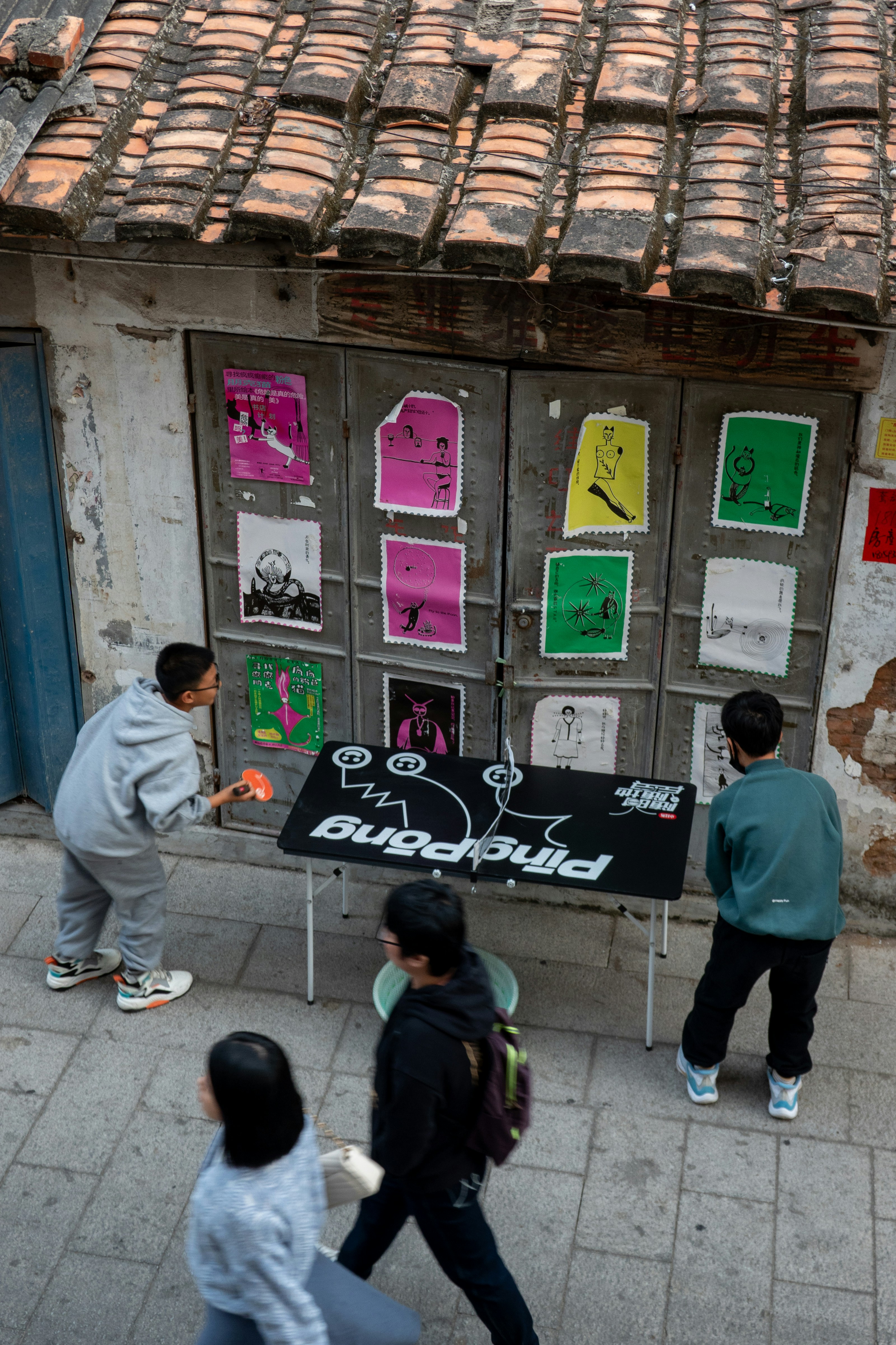 Street Ping-Pong Break: A Table Between Pedestrians and a Wall of Posters
