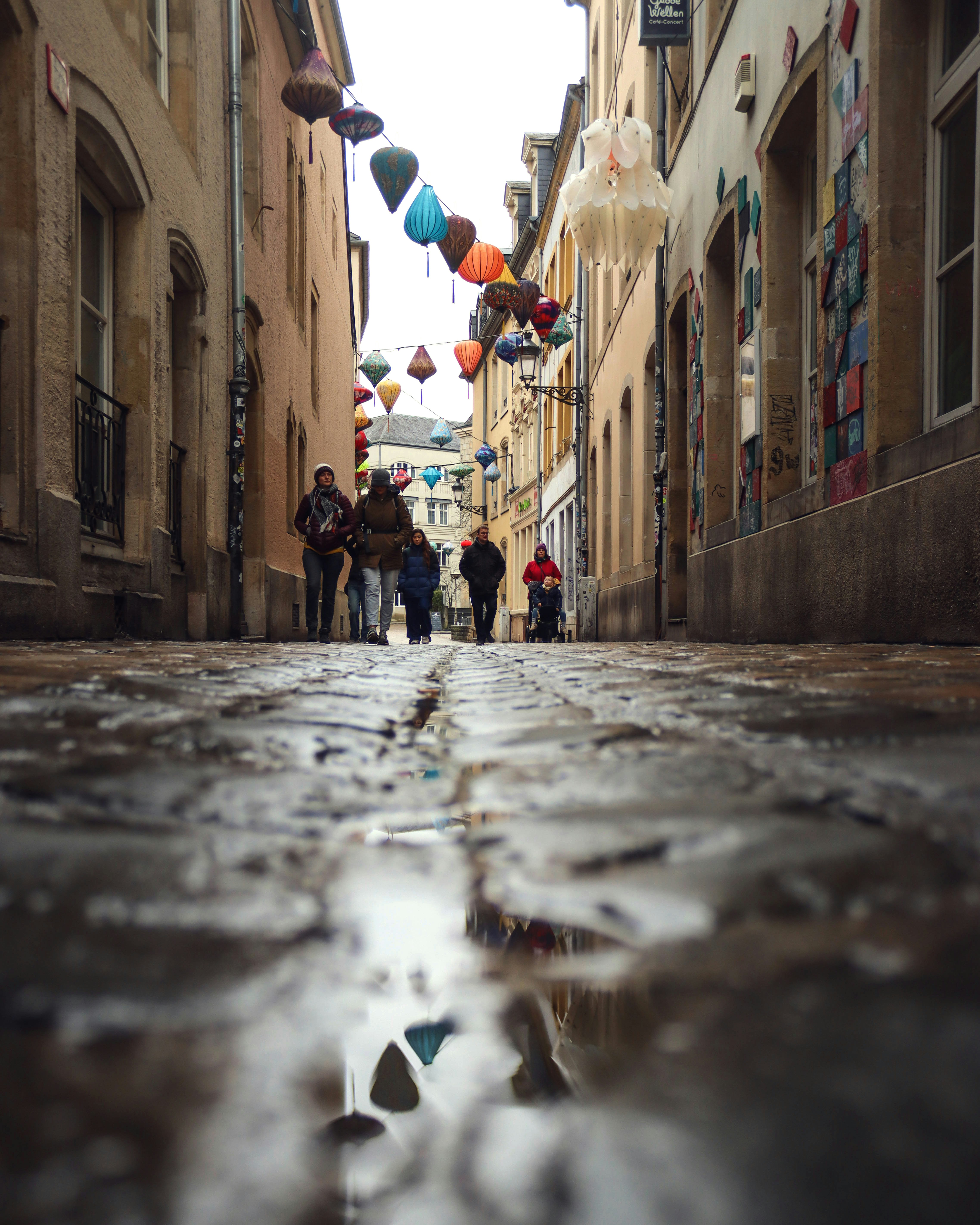 Lanterns Over the Lane: Footsteps on a Wet Cobblestone Street