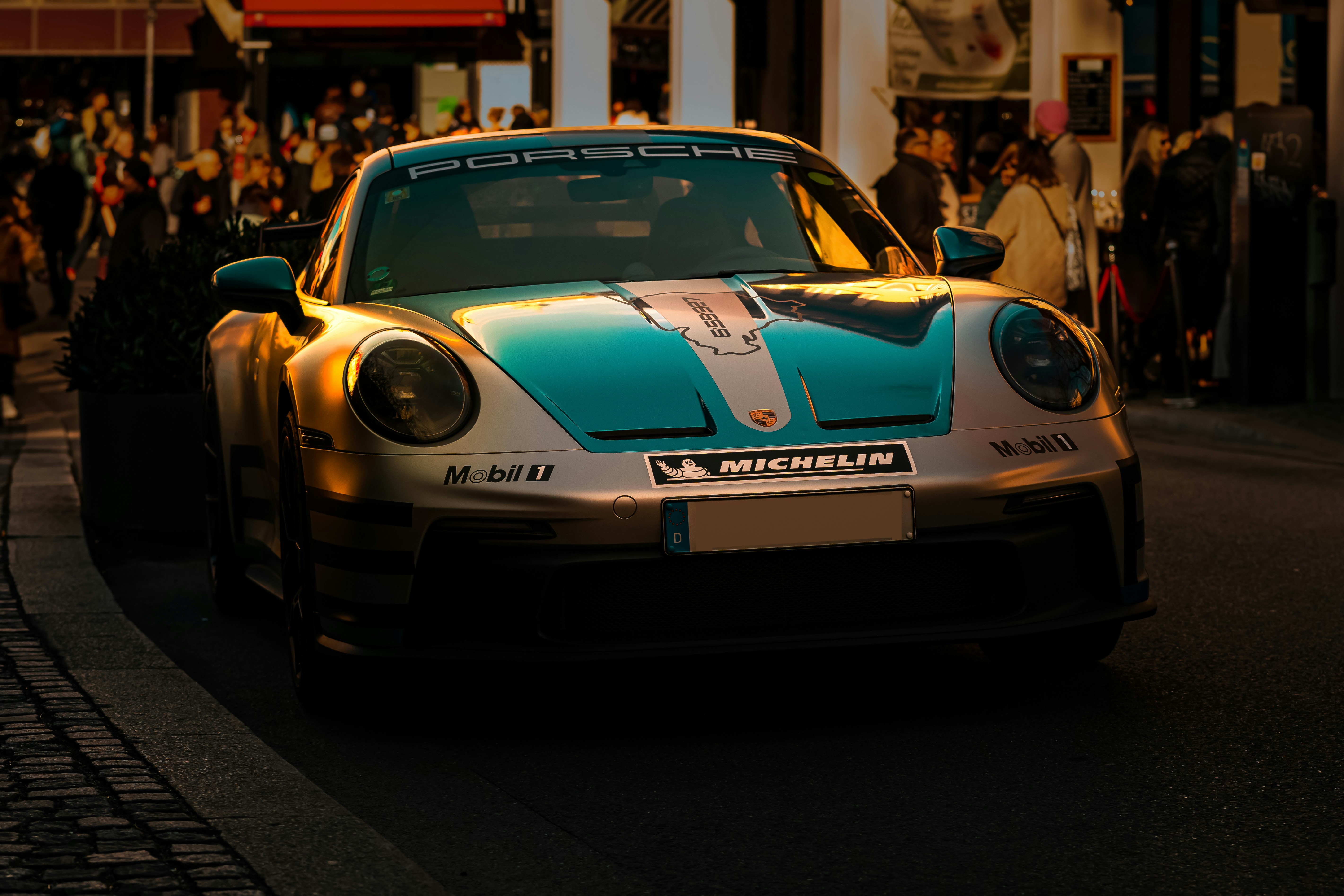 Teal-Striped Porsche on a Cobblestone Promenade at Dusk