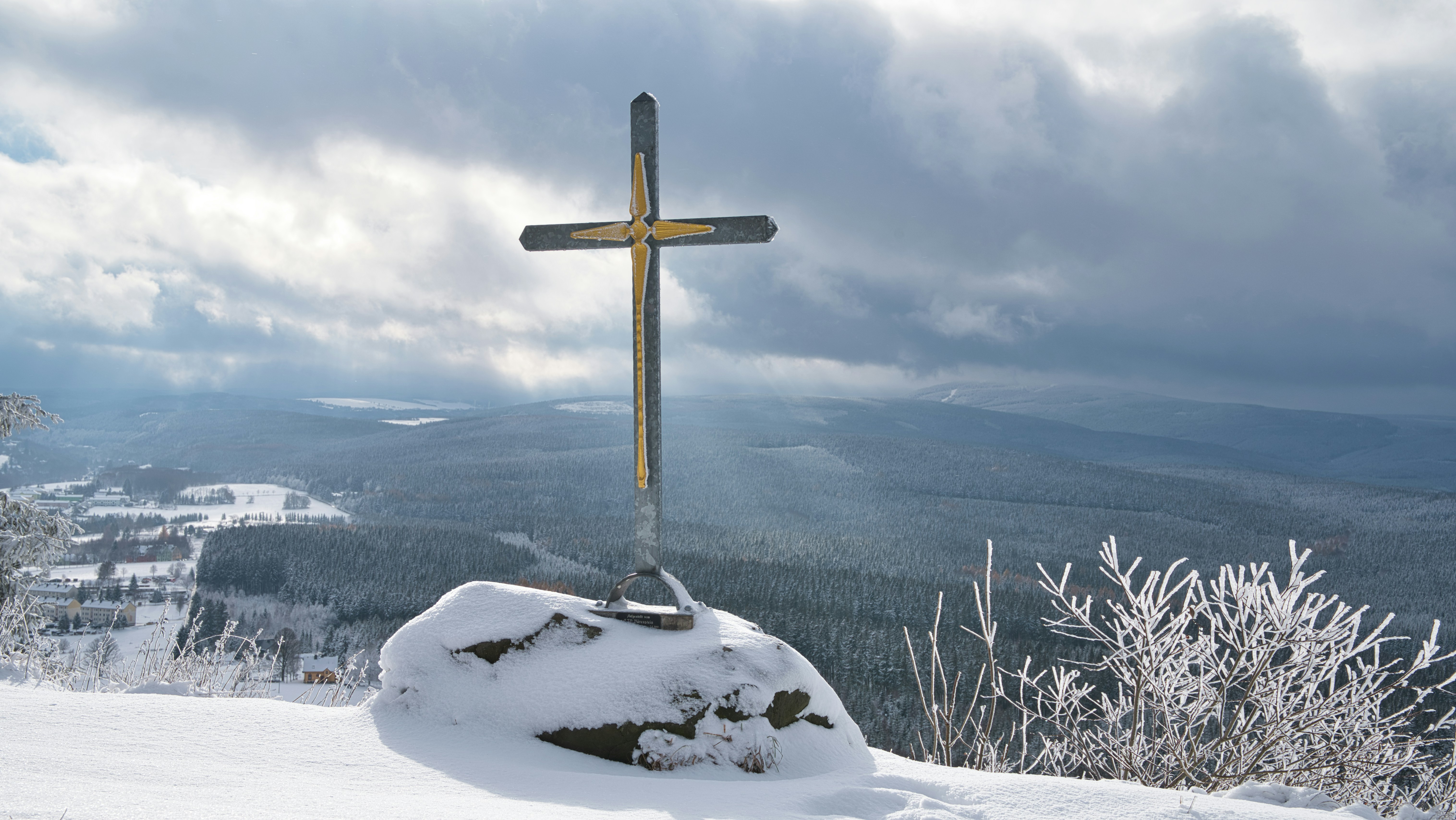 Winter Cross on a Snowbound Cairn Over a Frost-Kissed Alpine Valley