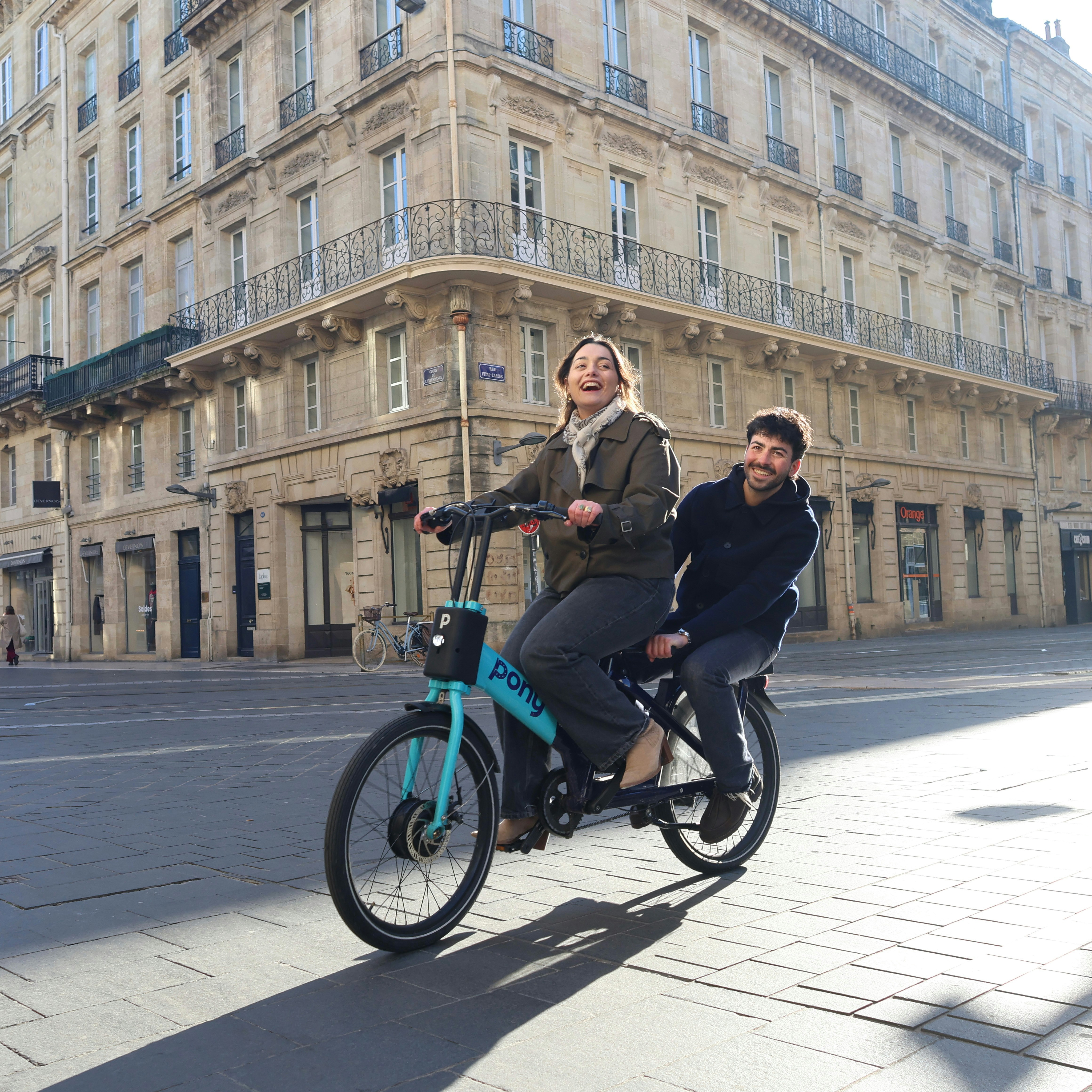 Two people riding a bike on a city street photo – Free Bordeaux Image ...