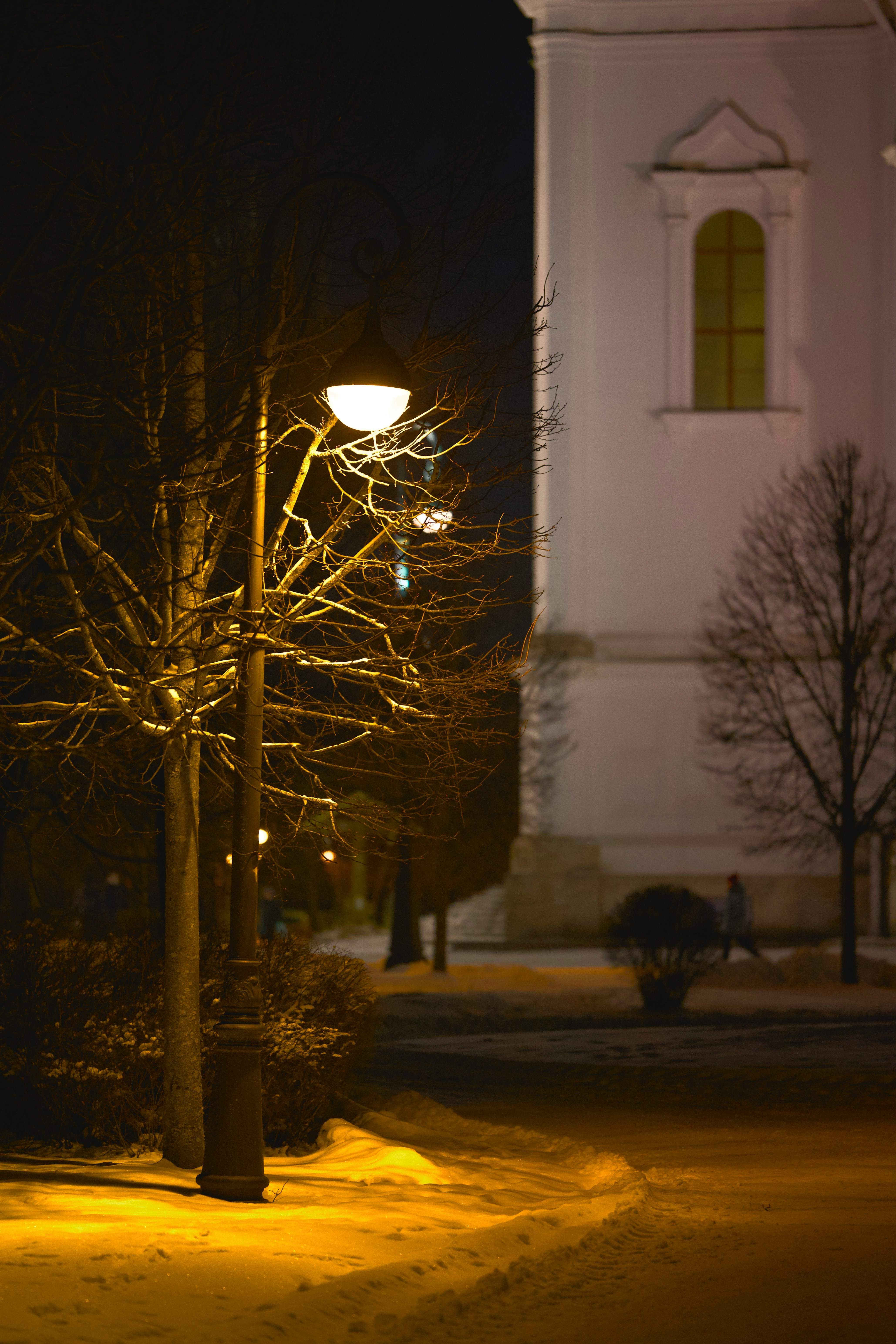 Lamplight on a Snow-Kissed Street Before a Church Facade