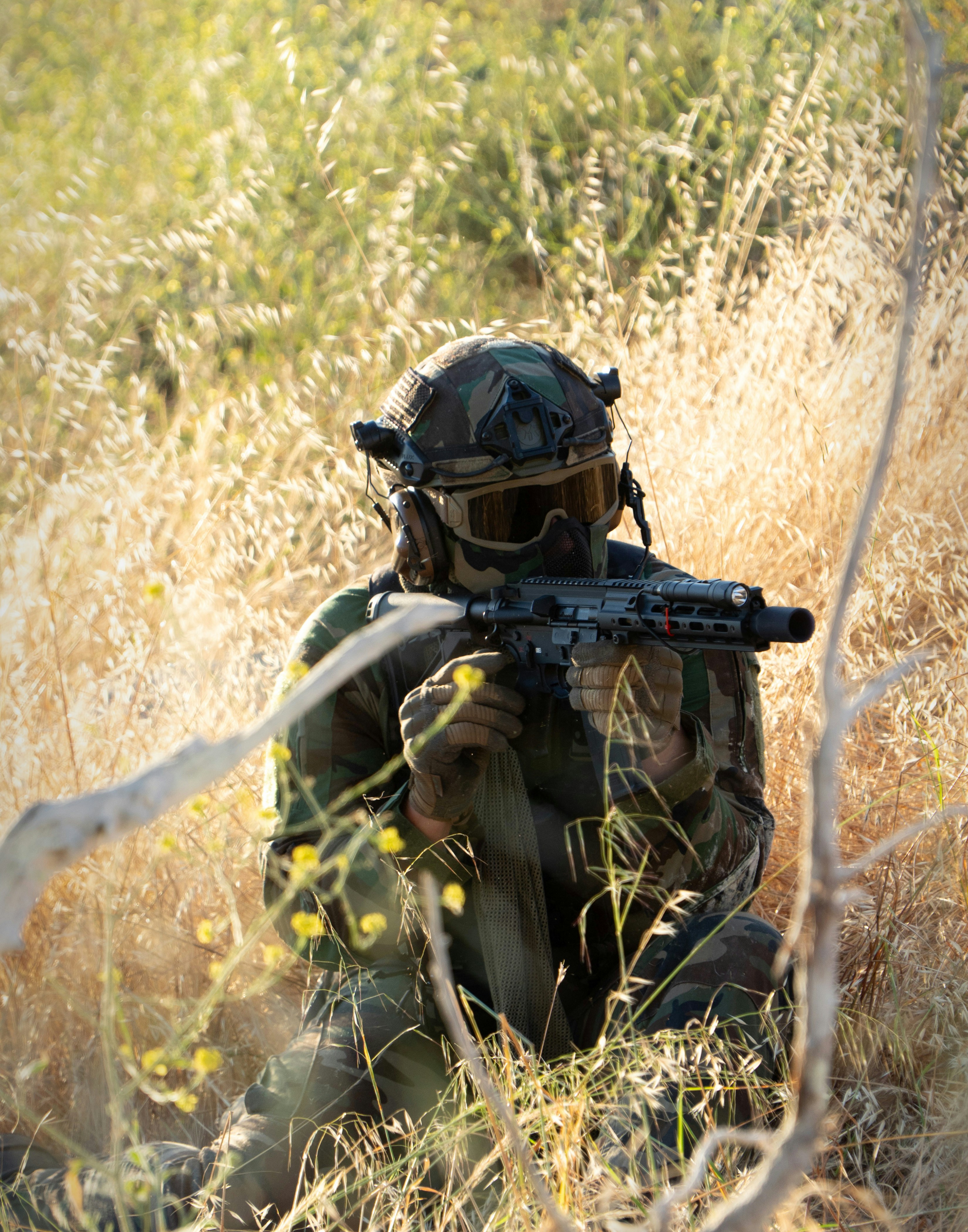 A soldier crouching in a field with a rifle photo – Free Army Image on ...