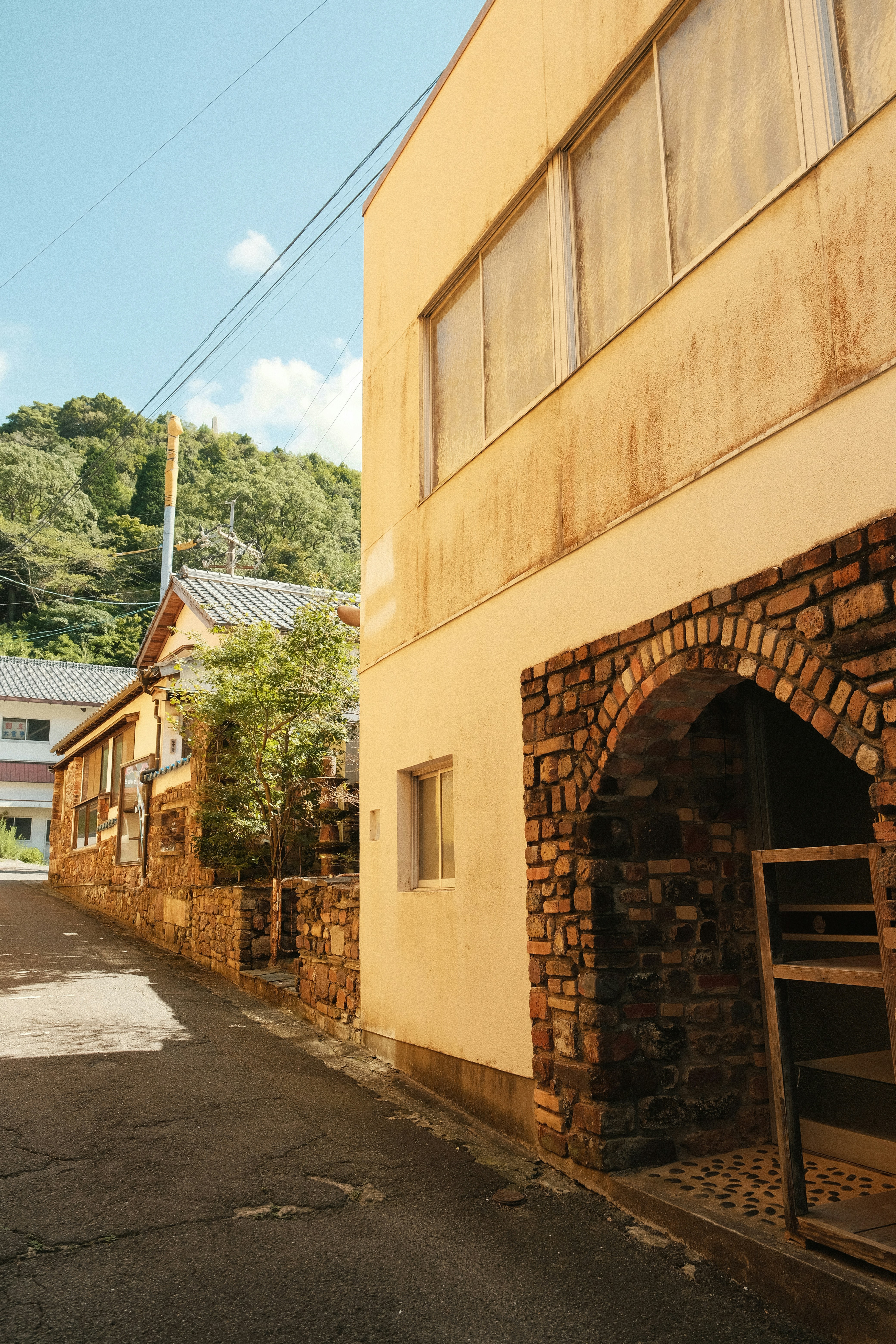 A narrow street with a brick archway between two buildings
