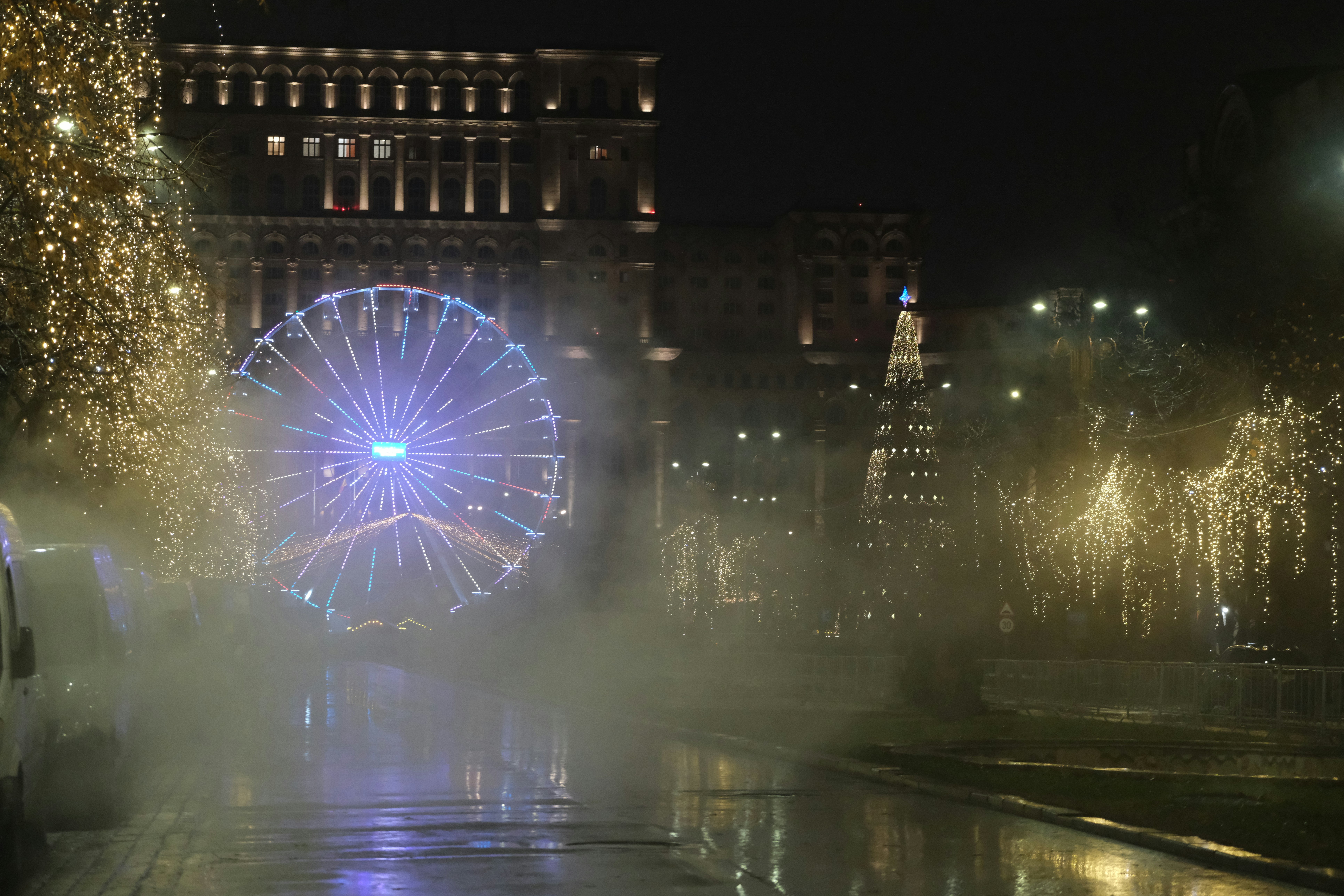Blue Ring in the Night Fog: Ferris Wheel Lights Crown a Winter Square