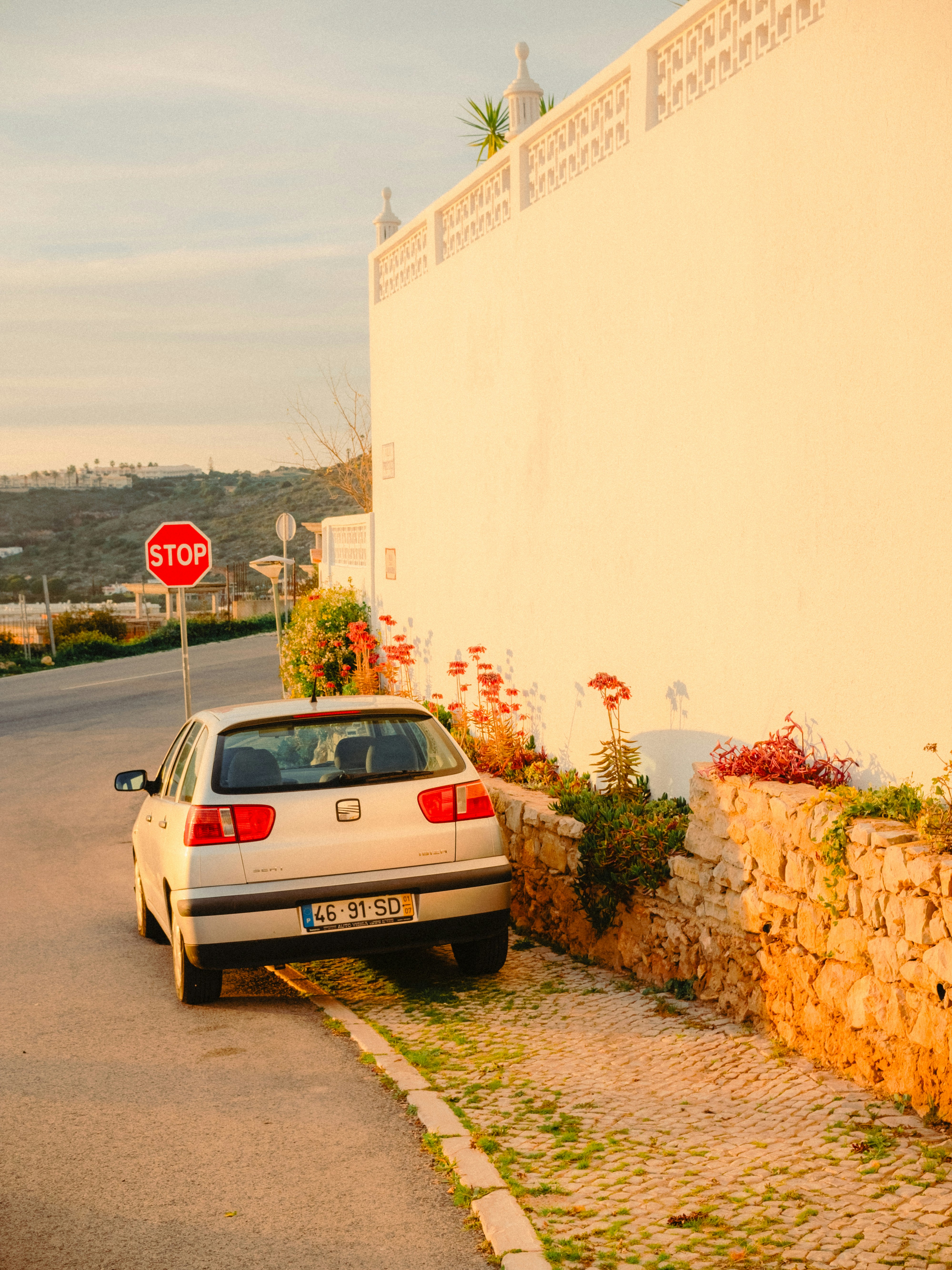 A car parked on the side of a road next to a stop sign
