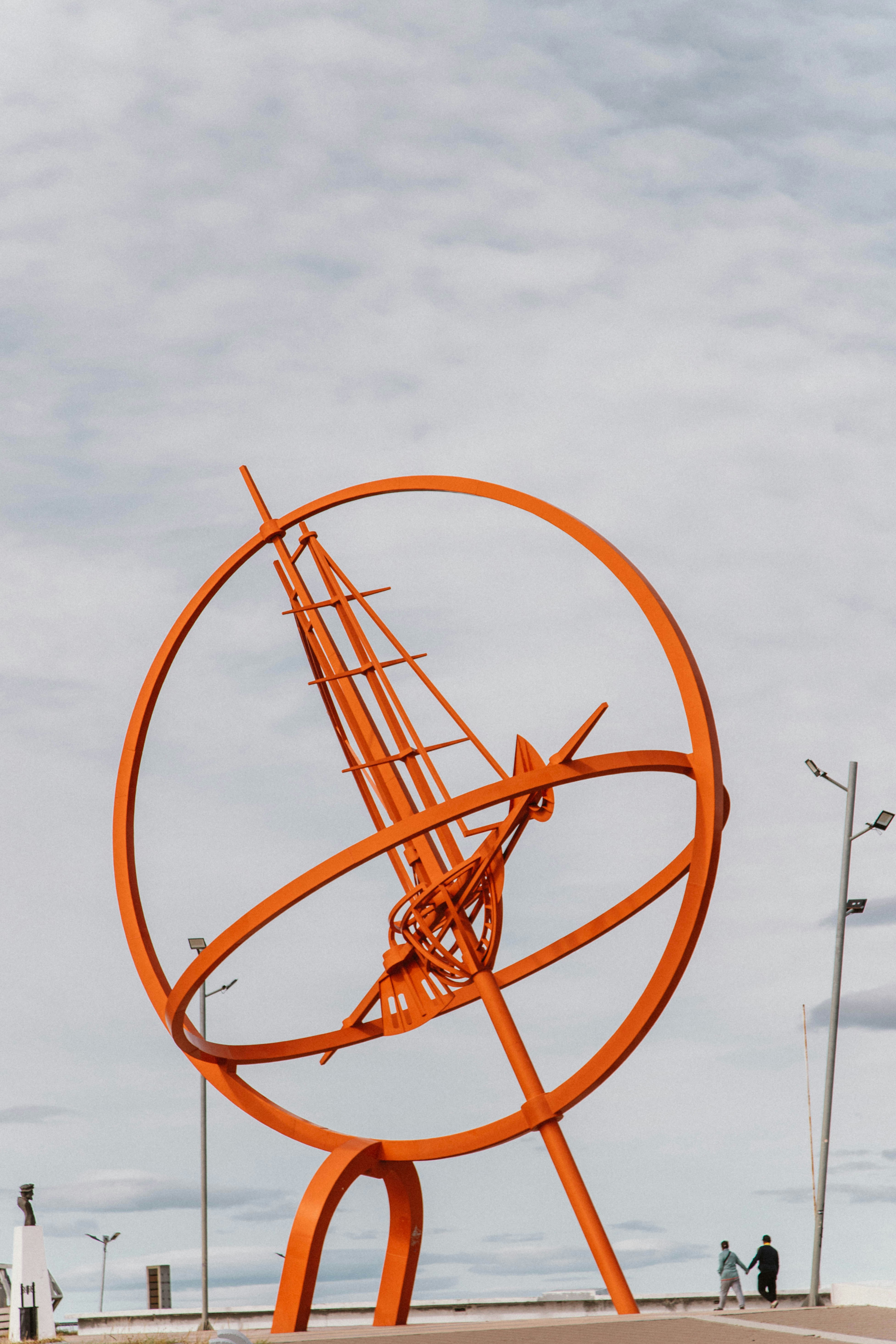 A large orange sculpture sitting on the side of a road photo – Free ...