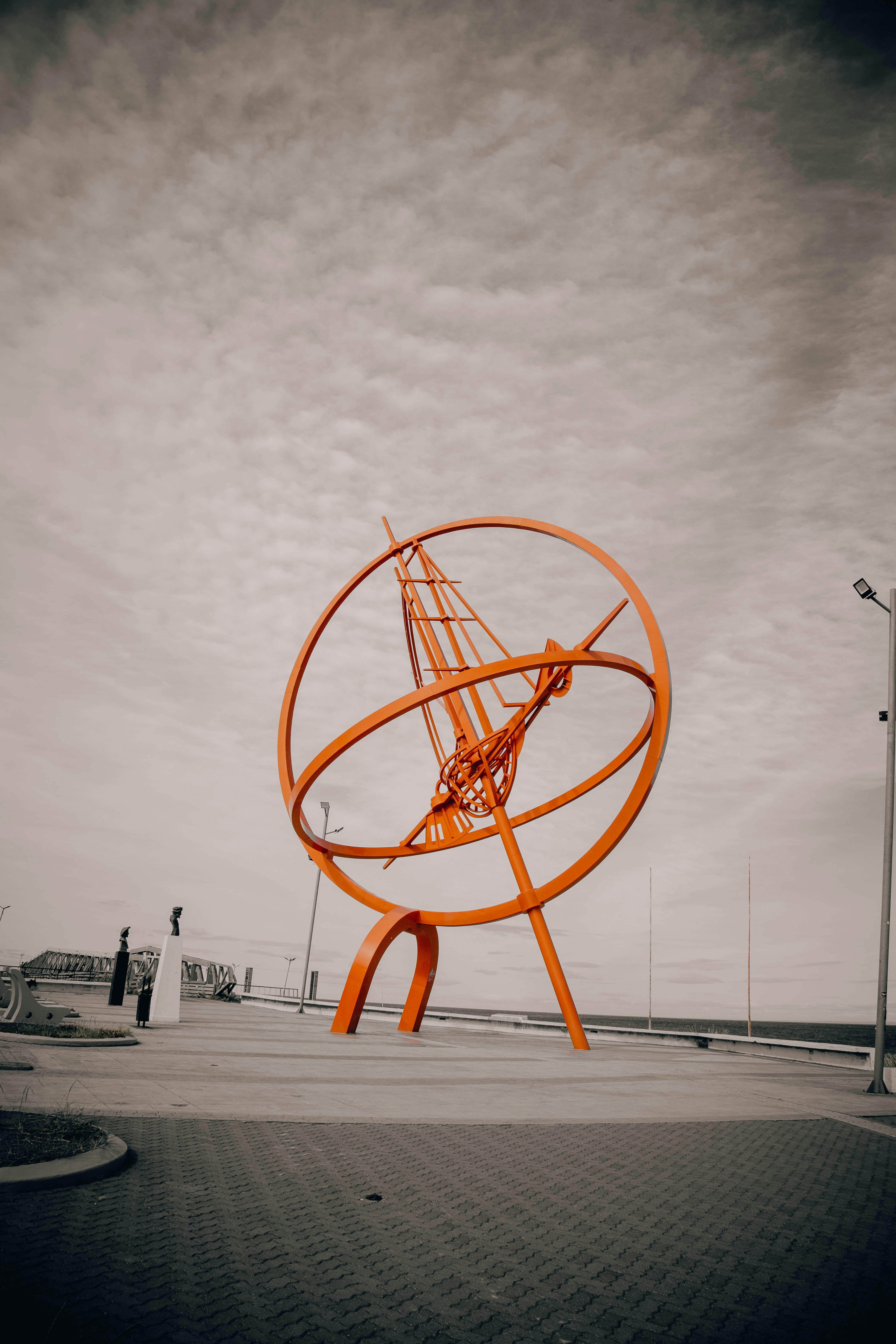 A large orange sculpture sitting on the side of a road photo – Free ...
