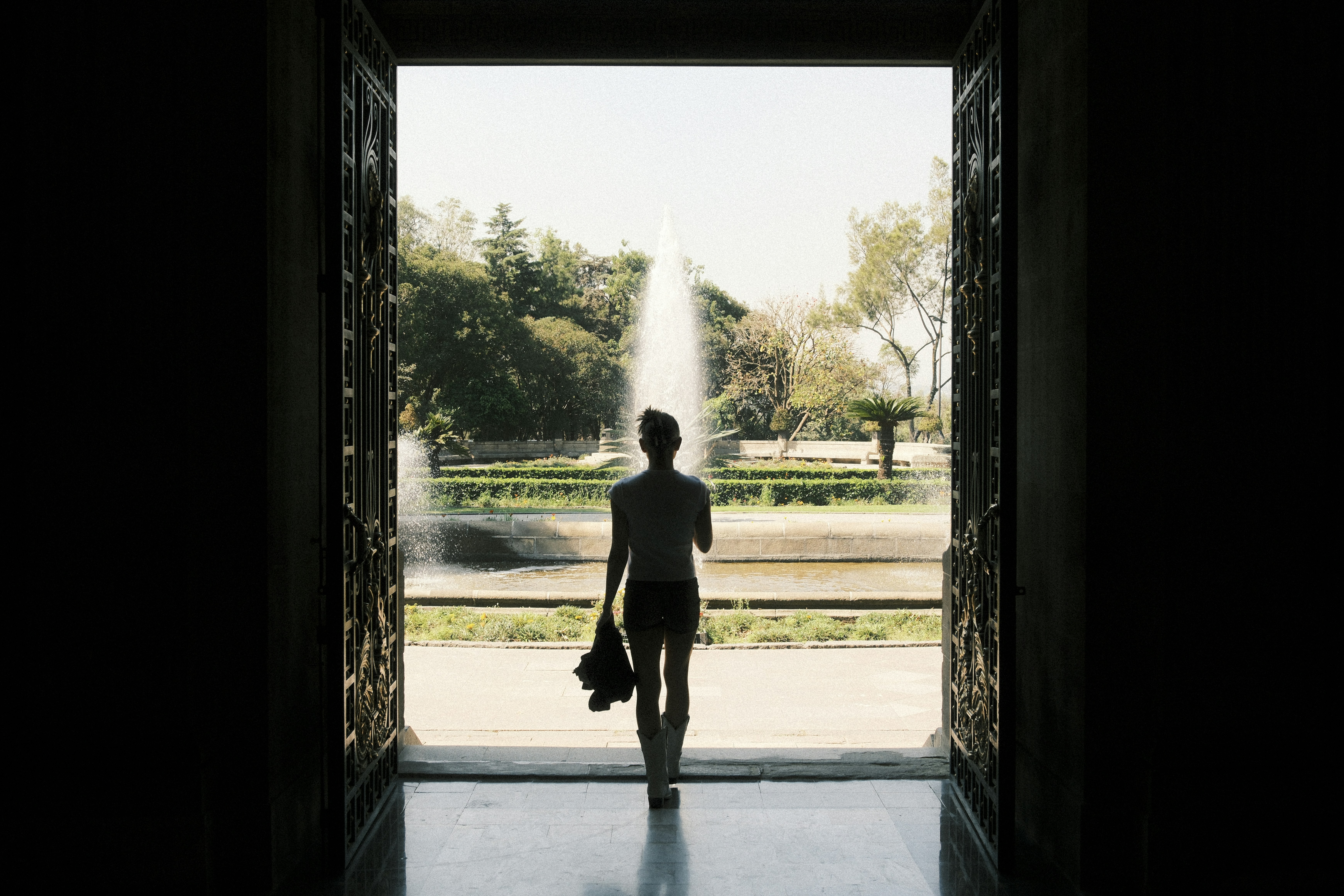 Through the Gateway: A Silhouette Steps into a Calm Courtyard