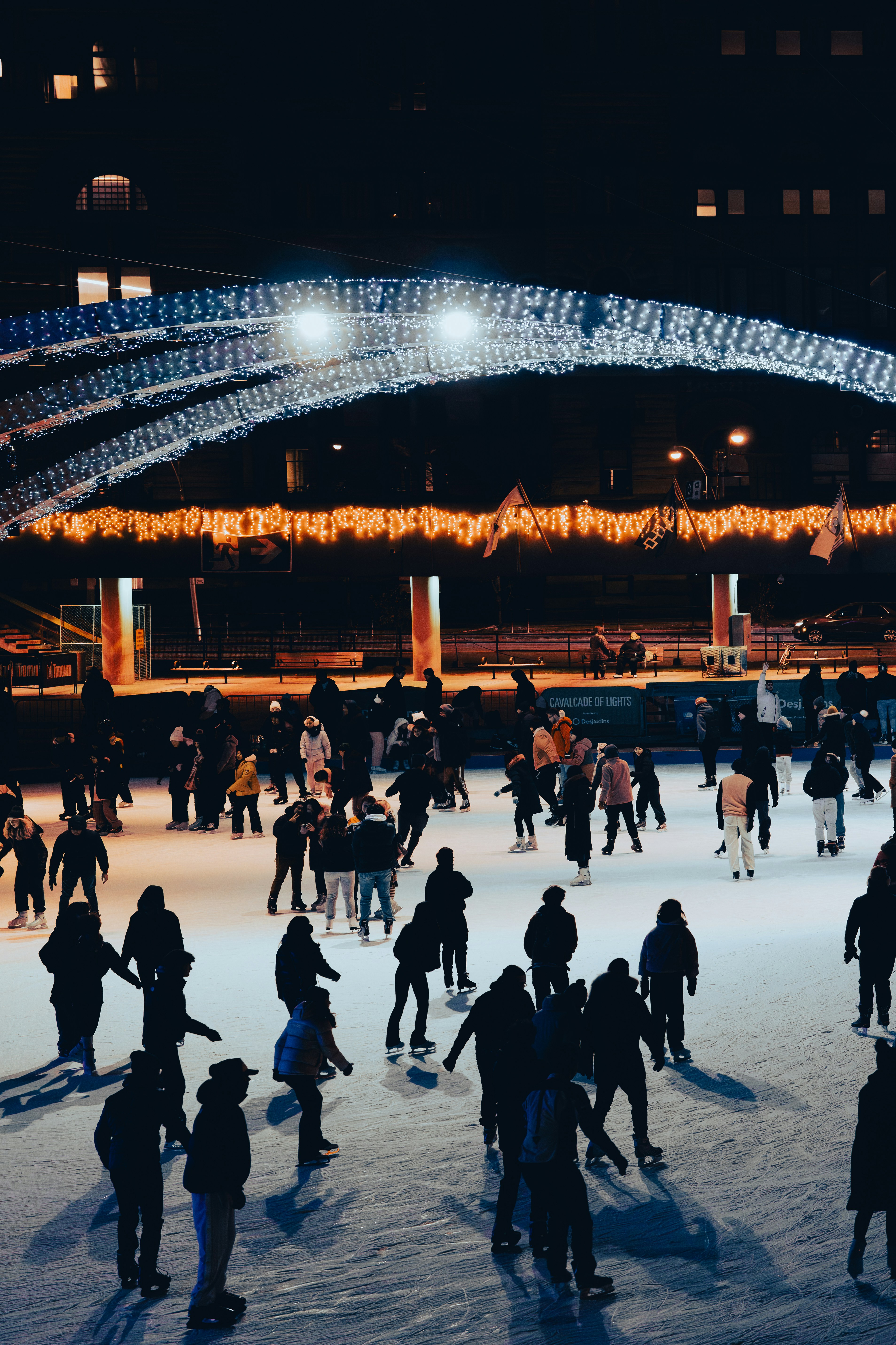A group of people skating on an ice rink at night photo – Free Toronto ...