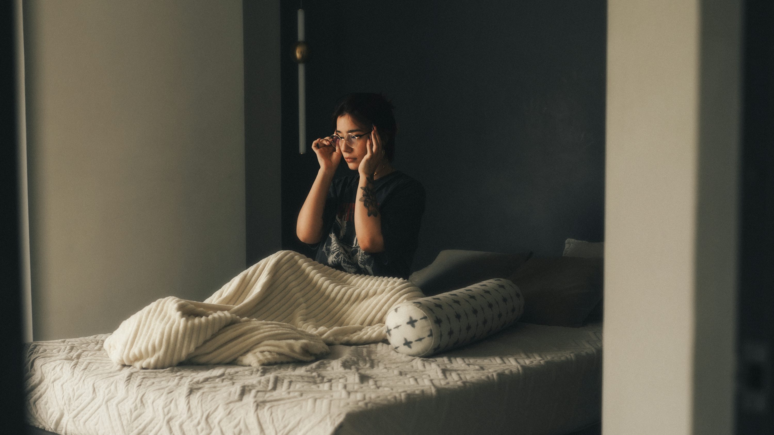 Una persona sentada en una cama en una habitación foto – Imagen de ... Una persona sentada en una cama en una habitación foto – Imagen de ...