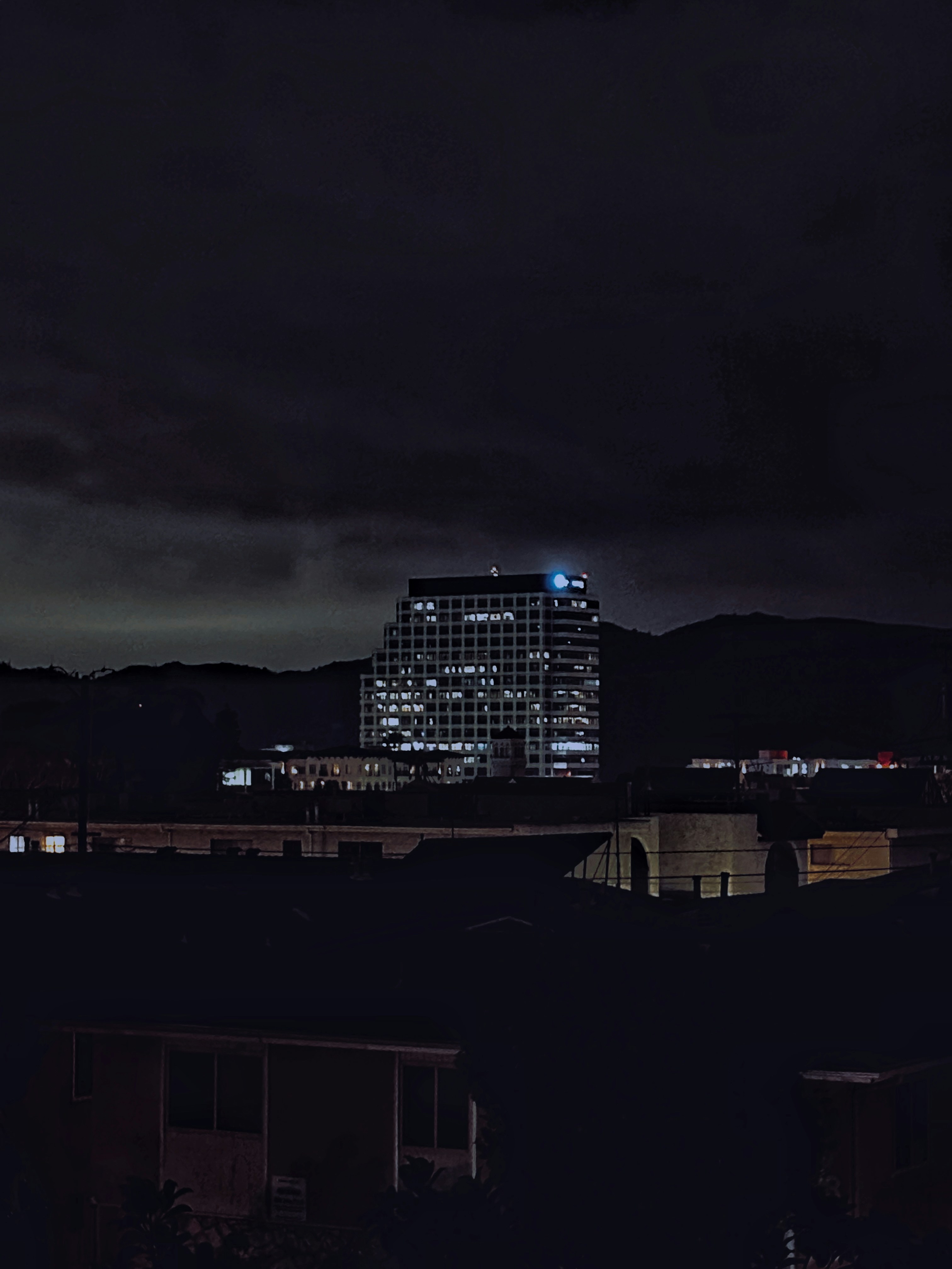 A night view of a city with a building lit up photo – Free Building ...