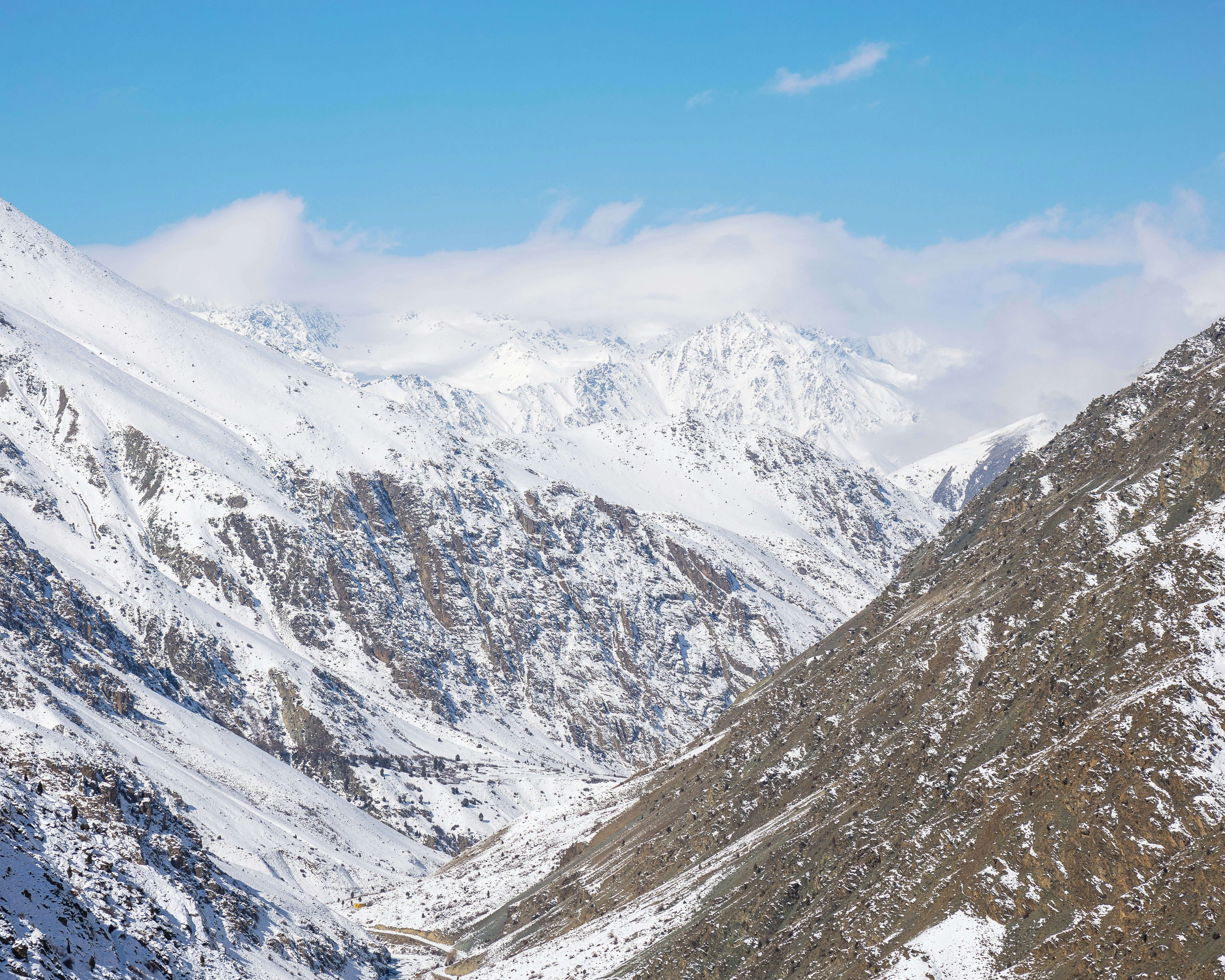 A snow covered mountain range with a sky background photo – Free Ice ...