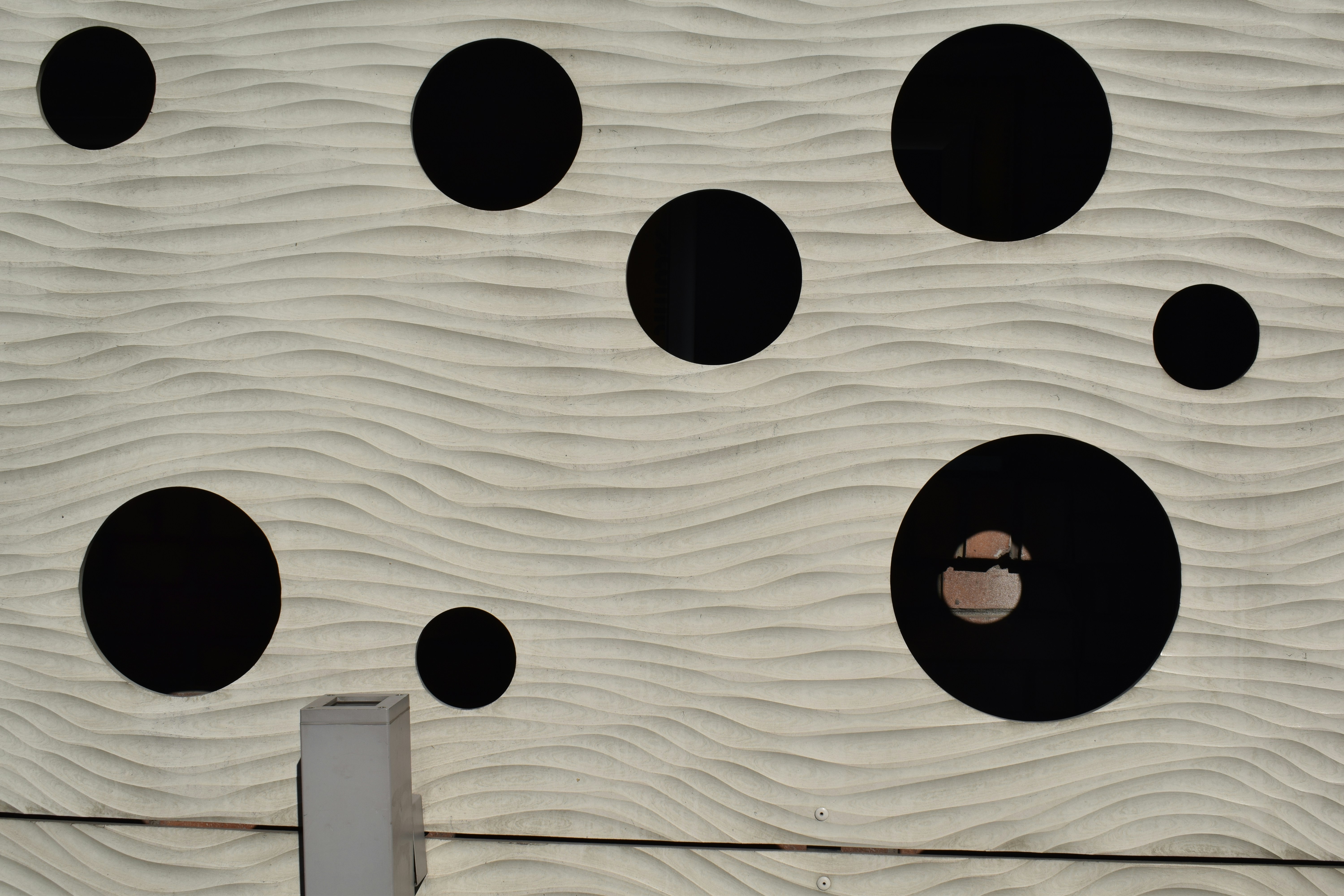 Black Circles on a Wave Textured Wall