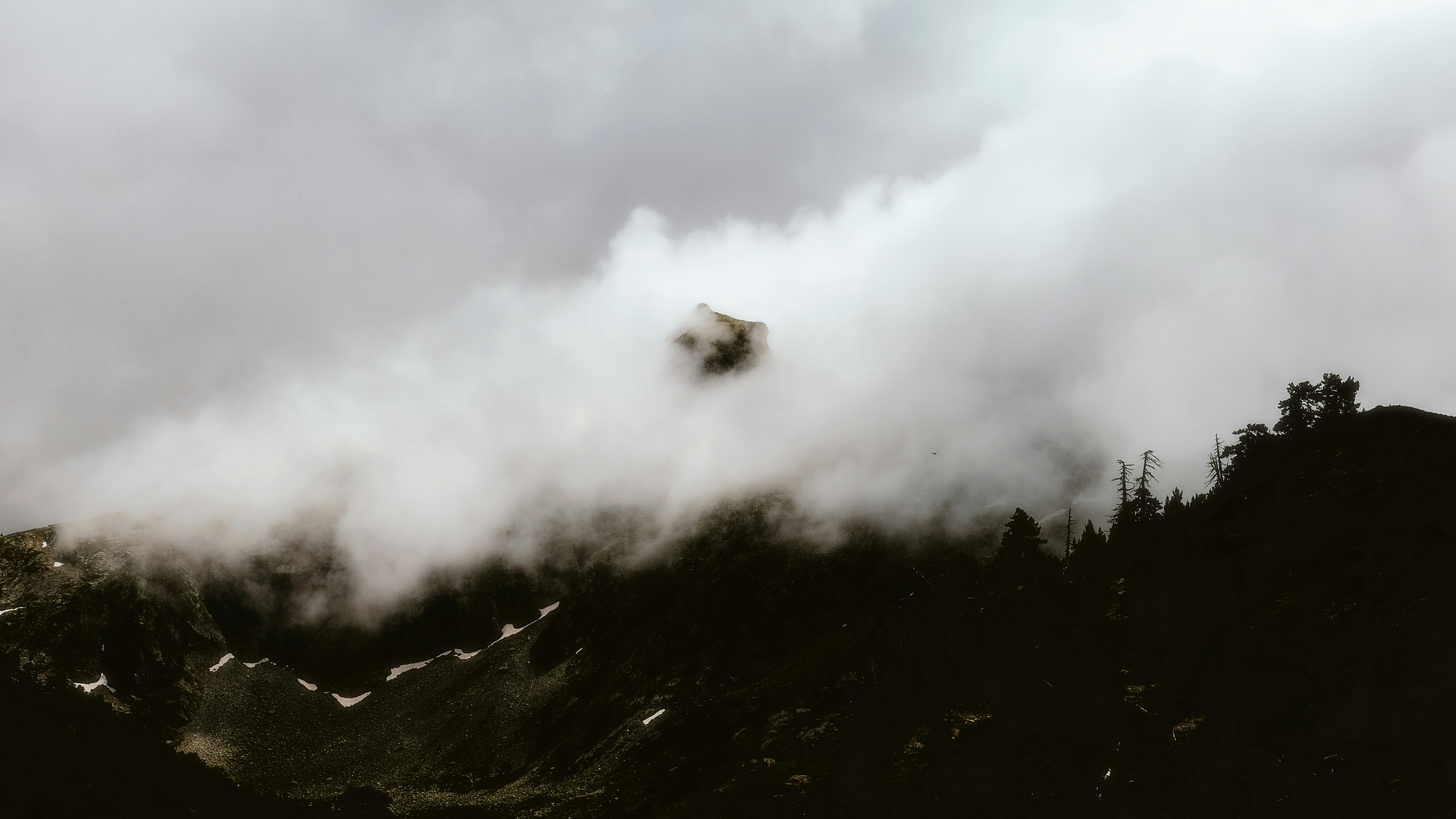 Mist-Breaking Summit: A lone peak emerges through the alpine cloud veil