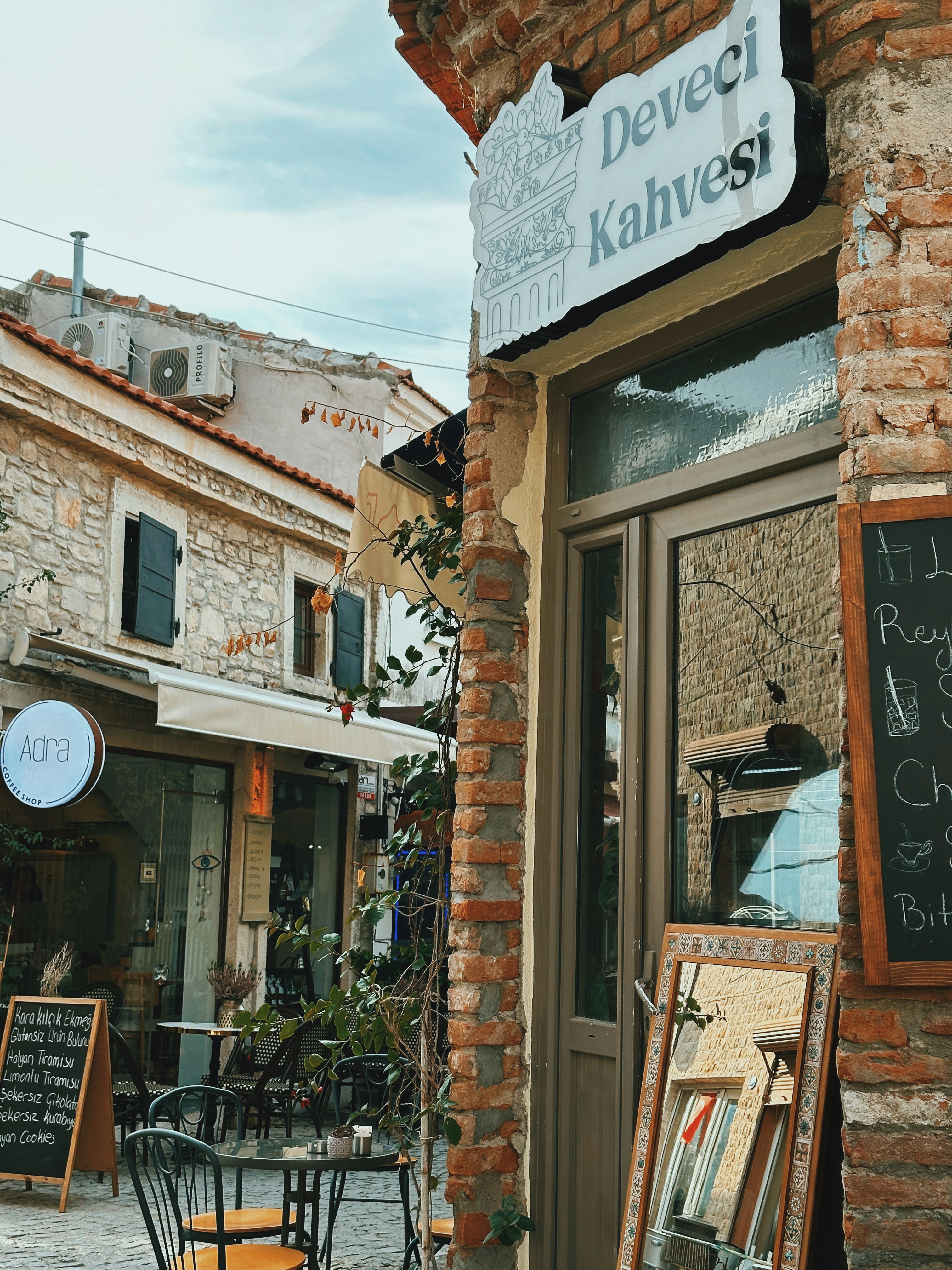 A street corner with a sign that says deliver kahvej photo – Free Urla ...