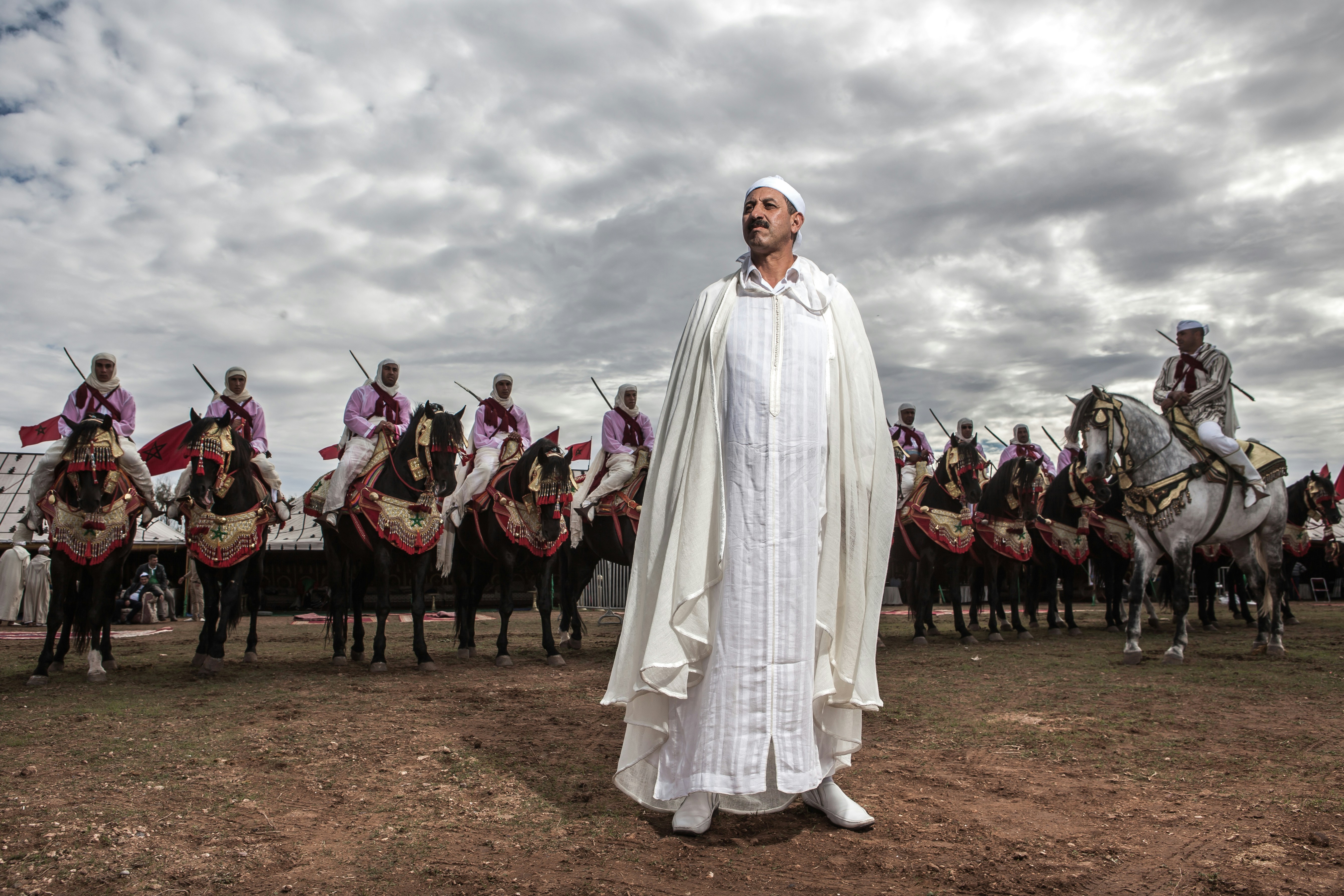 A man standing in front of a group of men on horses photo – Free Horse ...