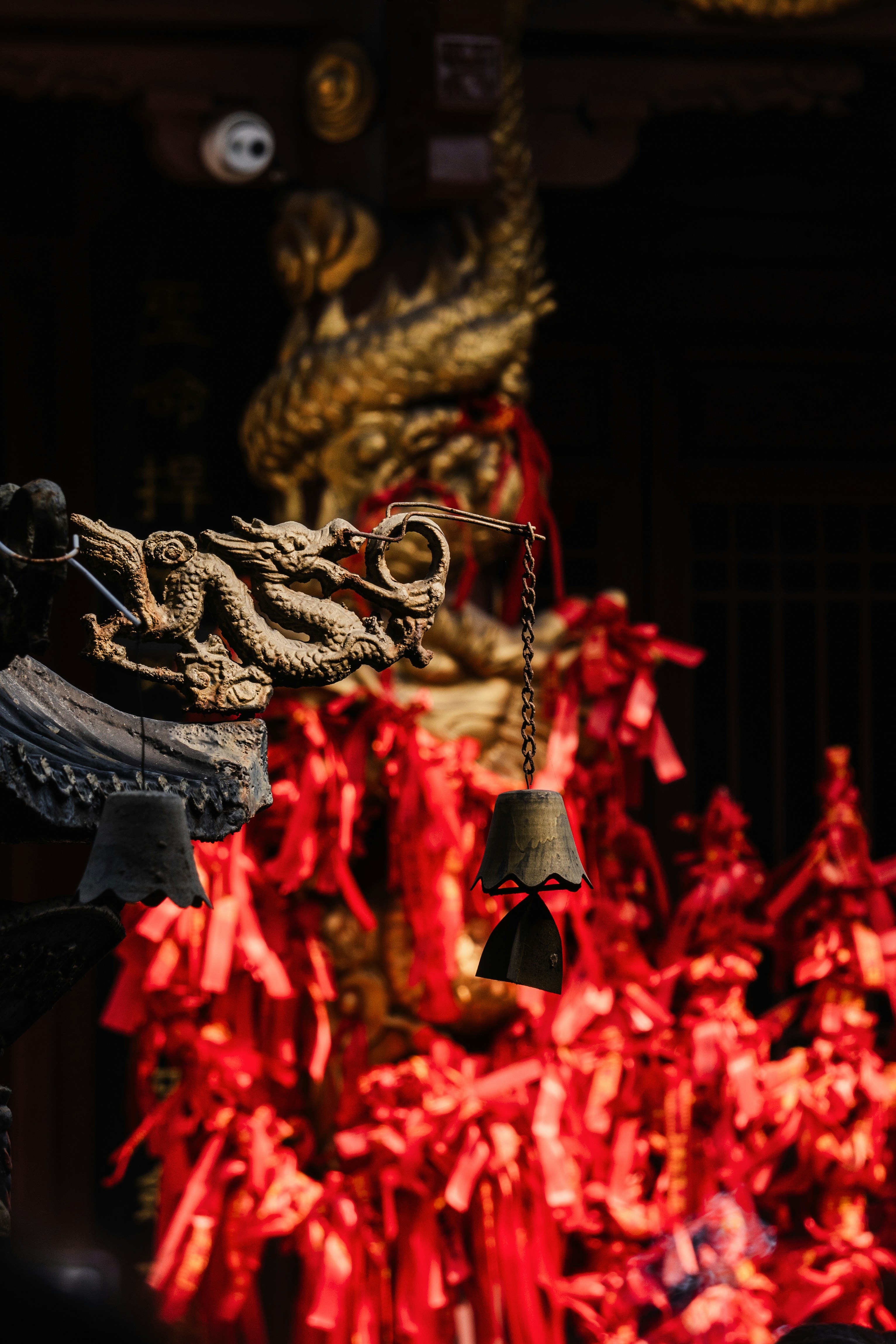 Dragon's Bell Pendant Amid Red Ribbons at a Shrine