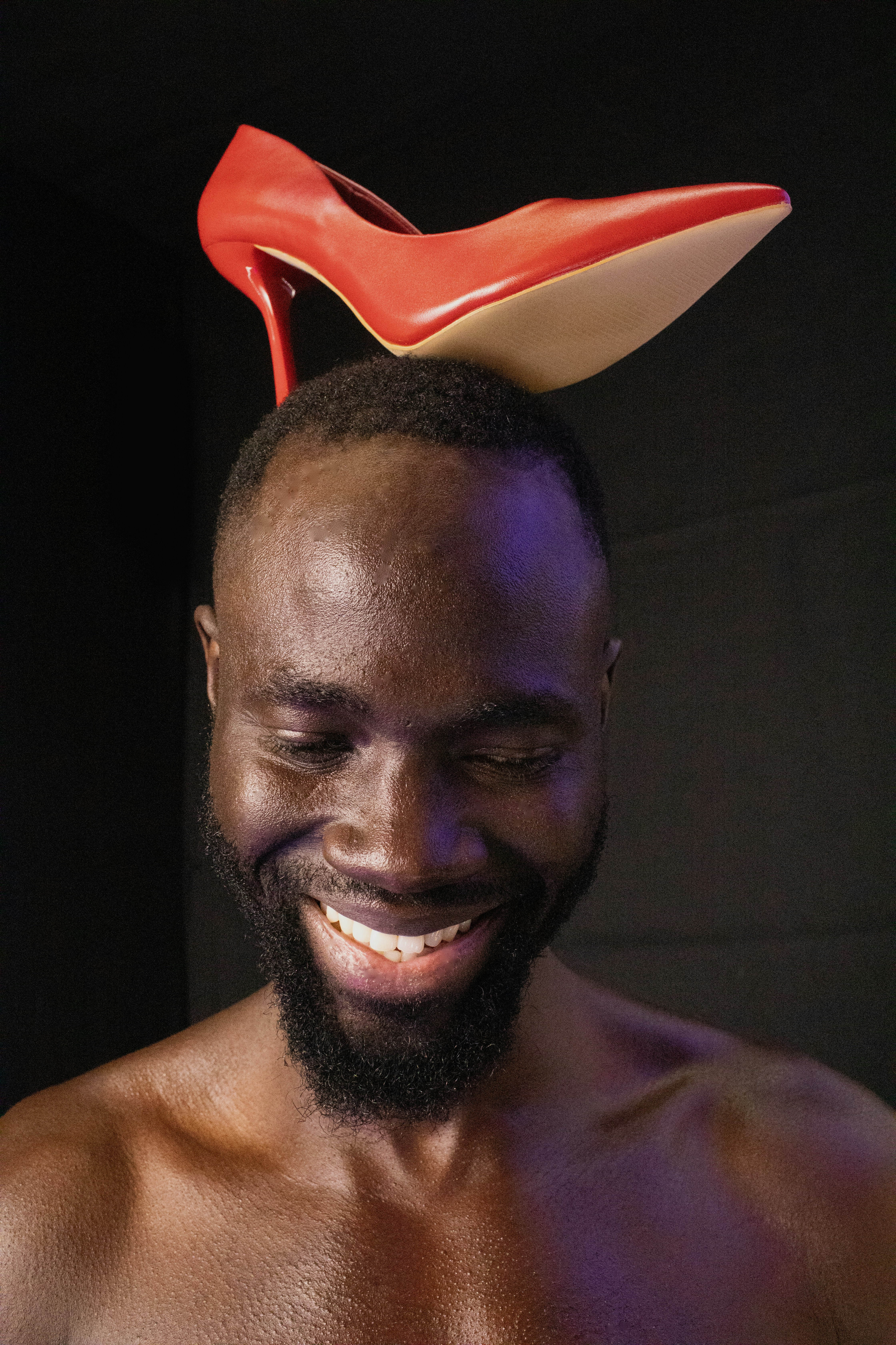 Crowned by a Red Heel: A Playful Portrait Under Velvet Purple Light