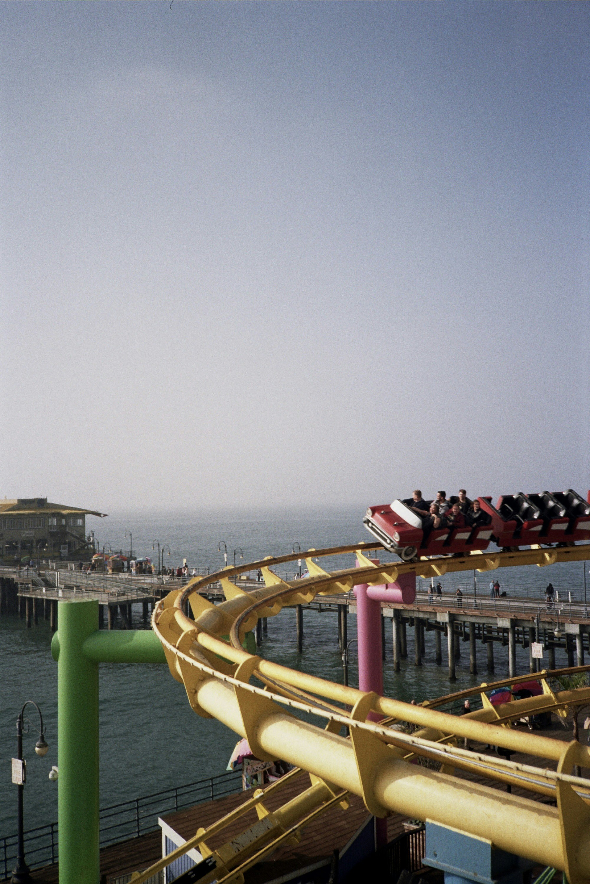 A roller coaster in front of a large body of water photo – Free Beach ...