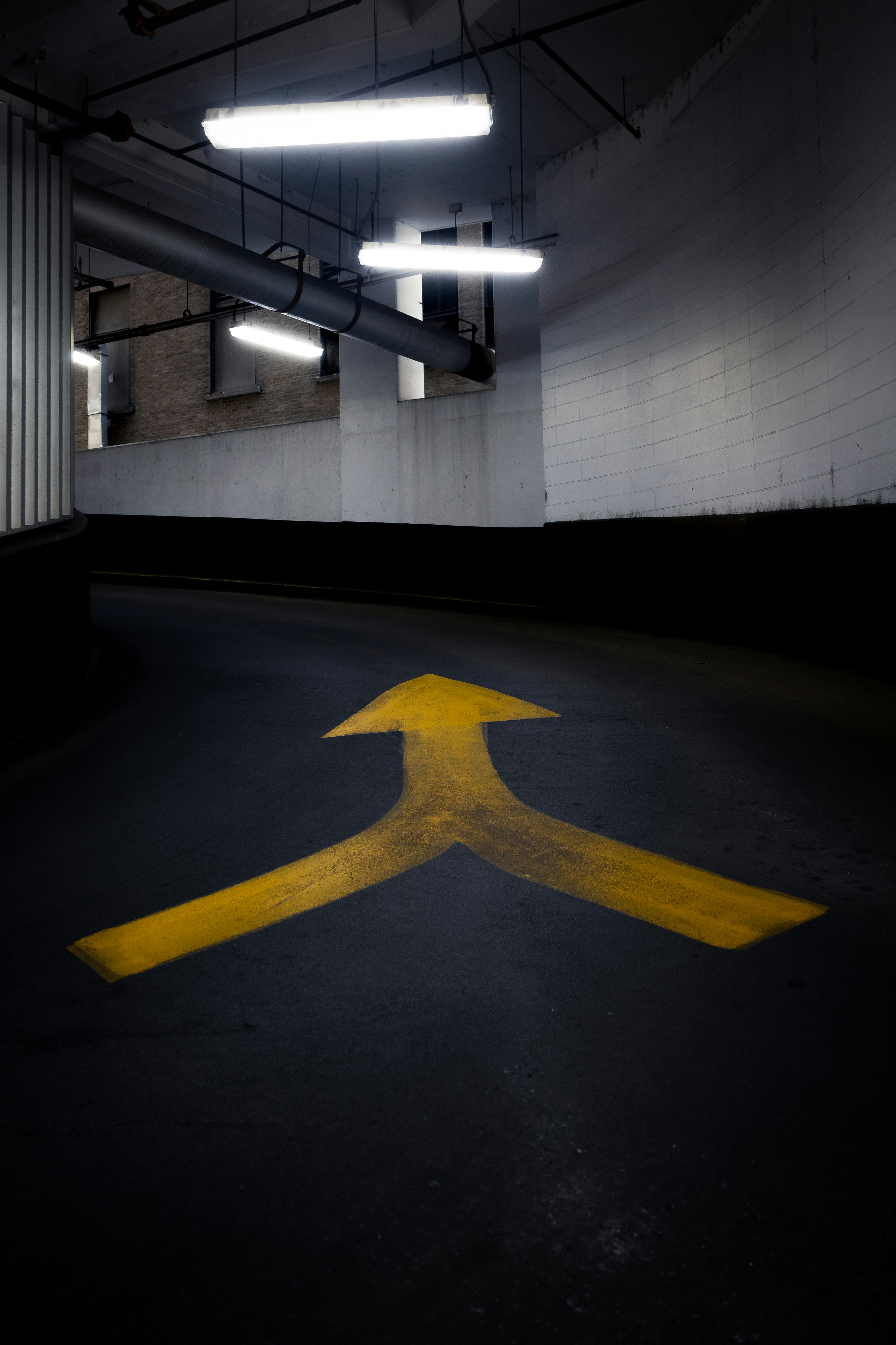 Arrow in the Dark: A Yellow Path Through an Underpass