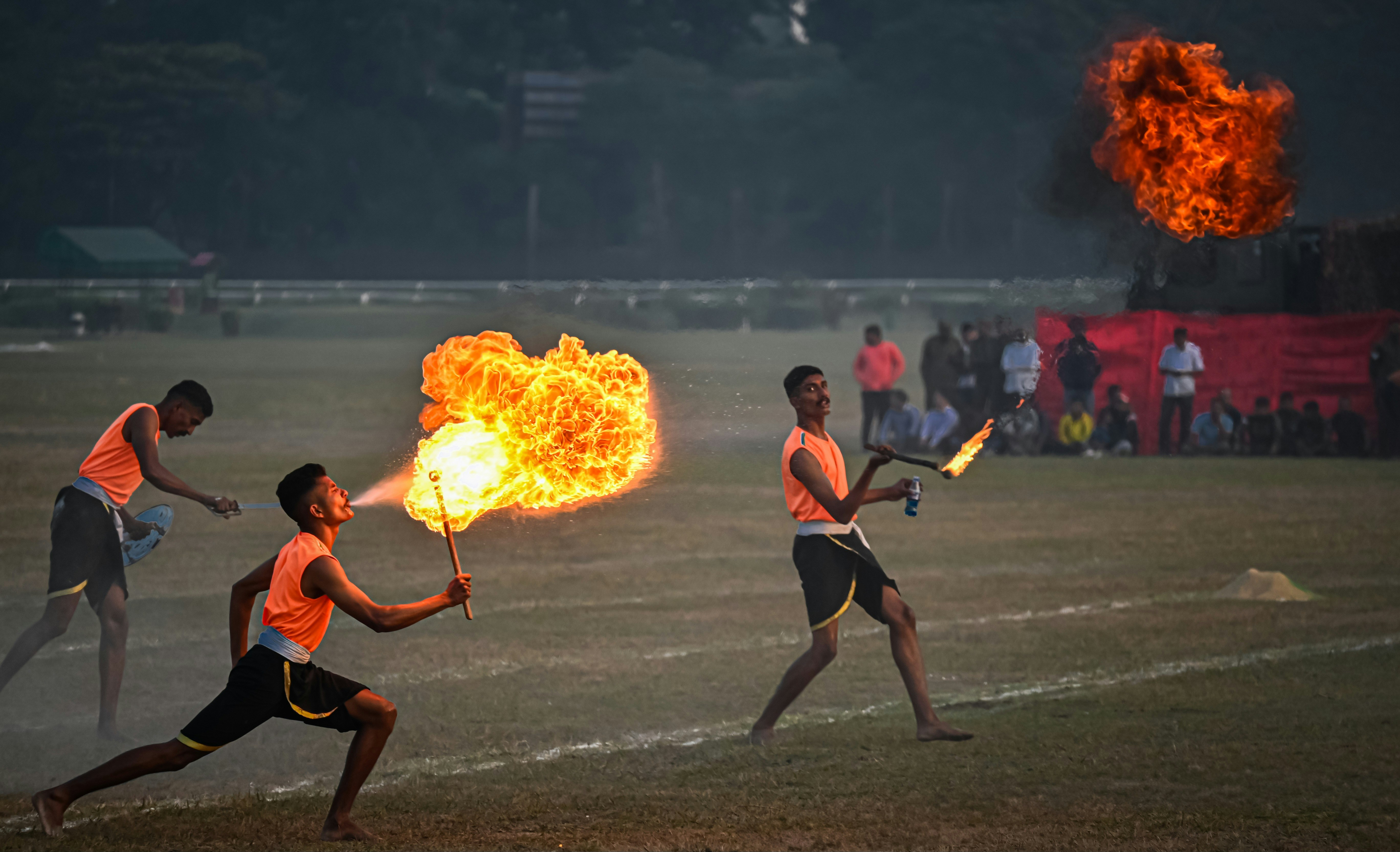 A group of men running across a field holding torches photo – Free ...