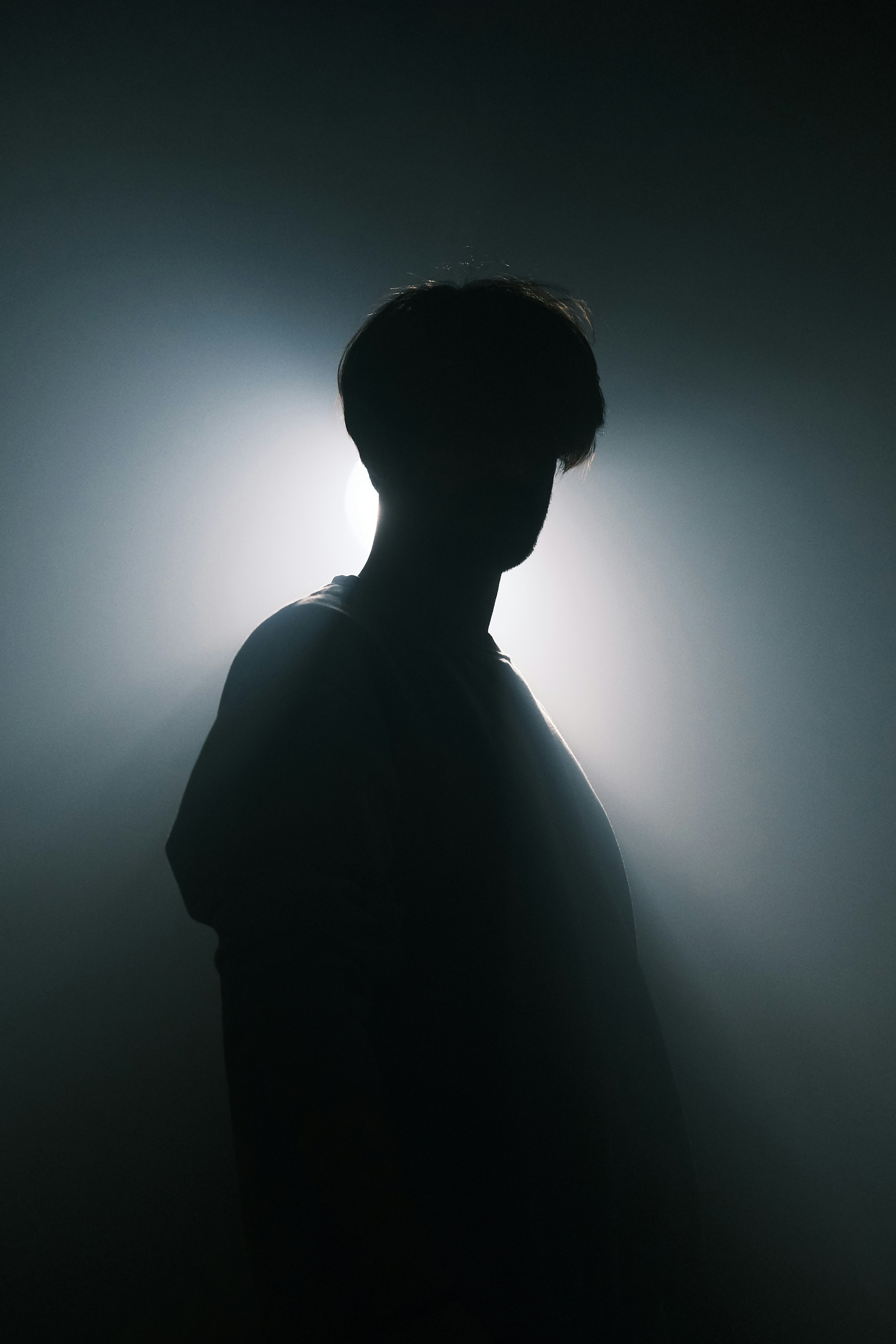 A person standing in the dark with a light behind them photo – Free ...